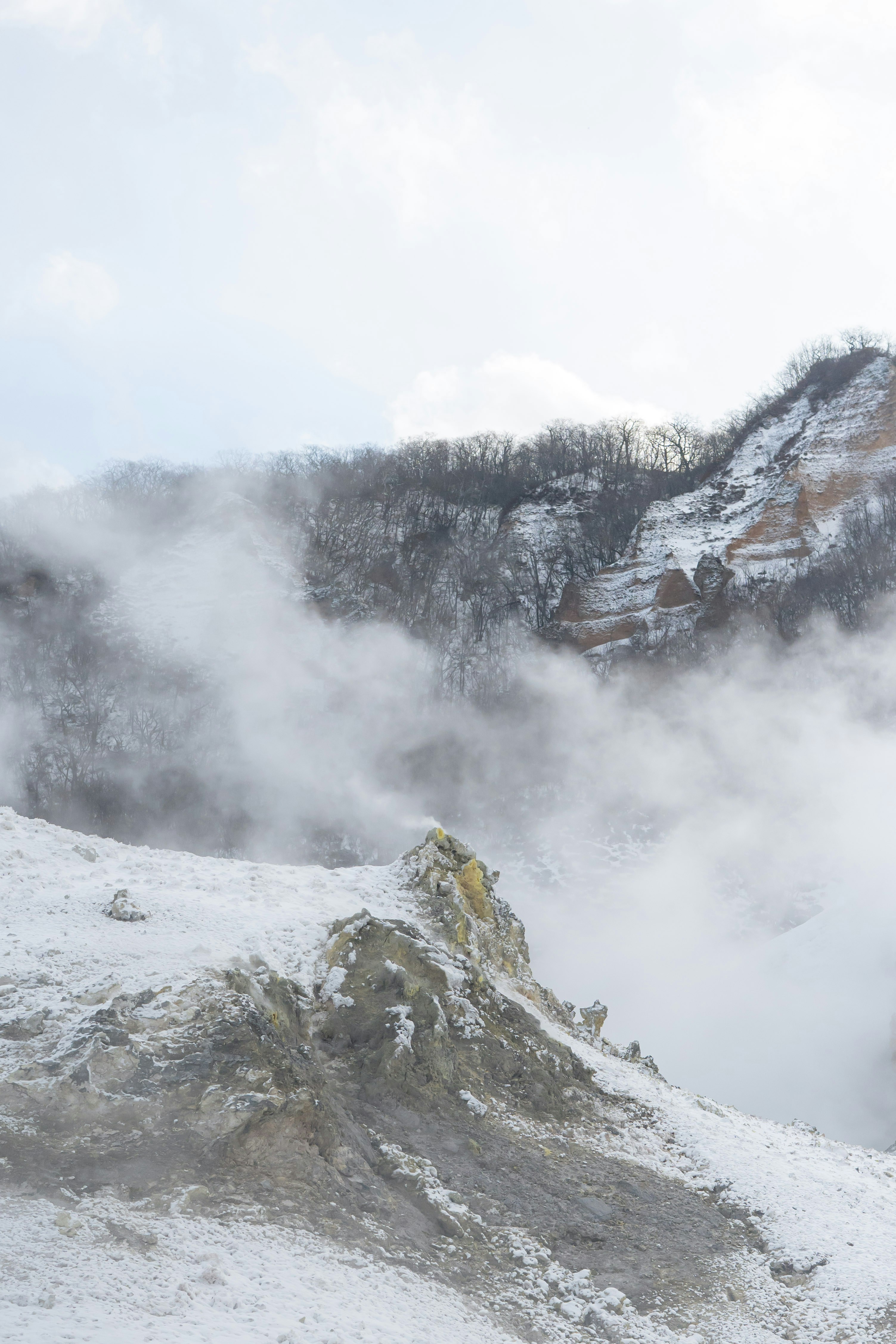 Mist over the Crag: Snow-Capped Ridge and Vapor