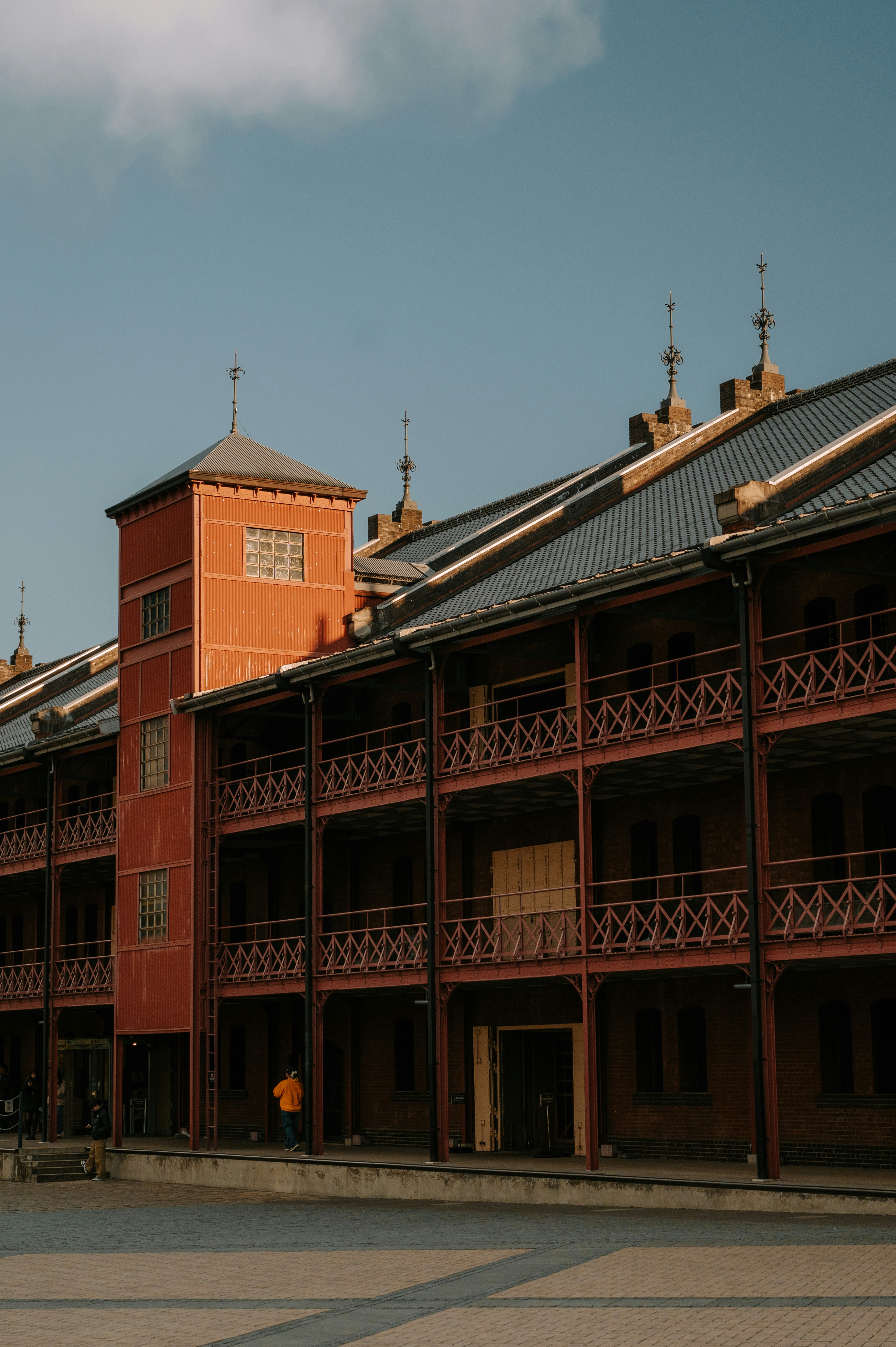 Red Brick Facade and Timbered Arcade Under a Clear Sky
