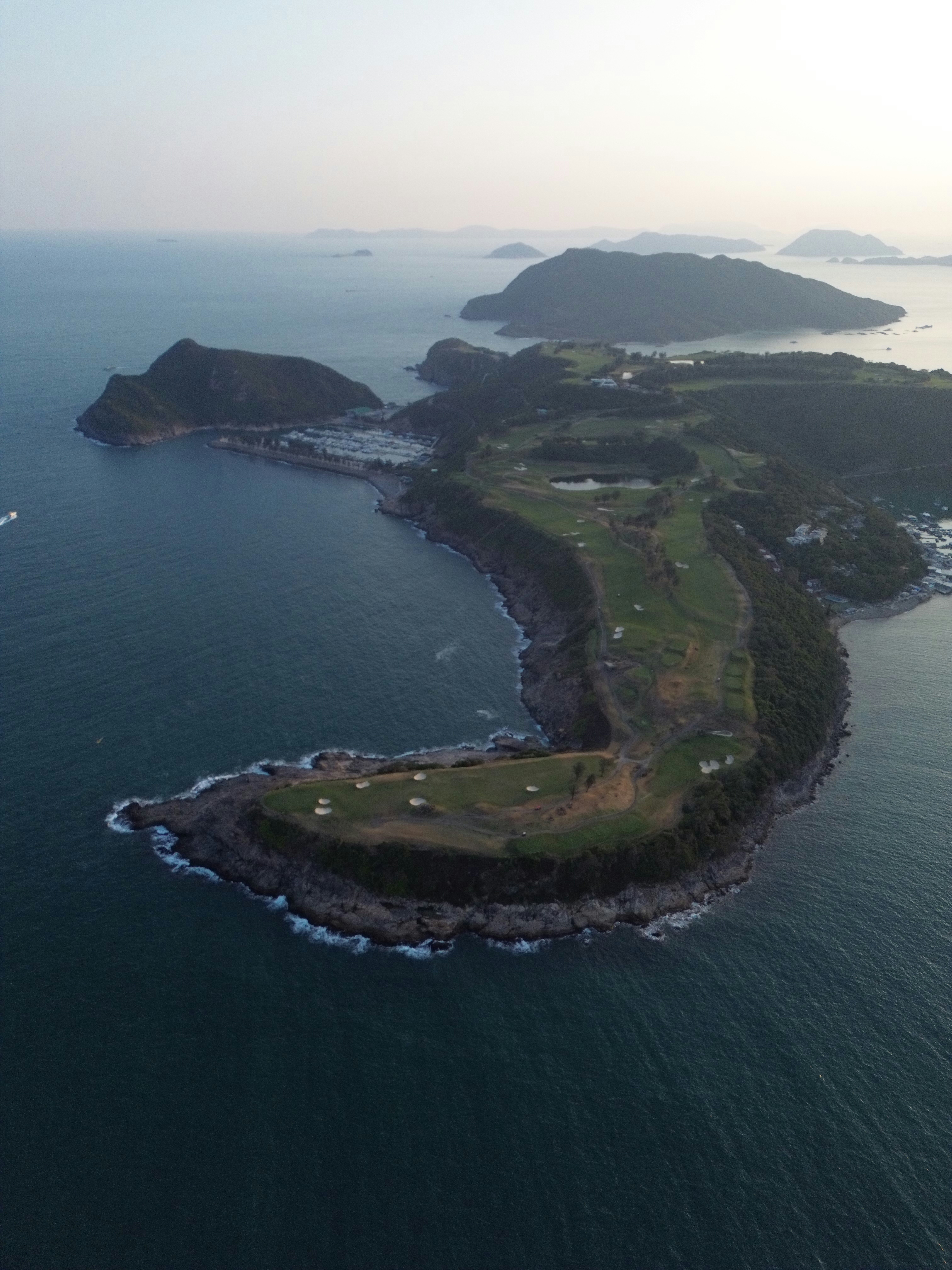 Aerial View of a Narrow Coastal Island with Golf Course Amid Calm Seas