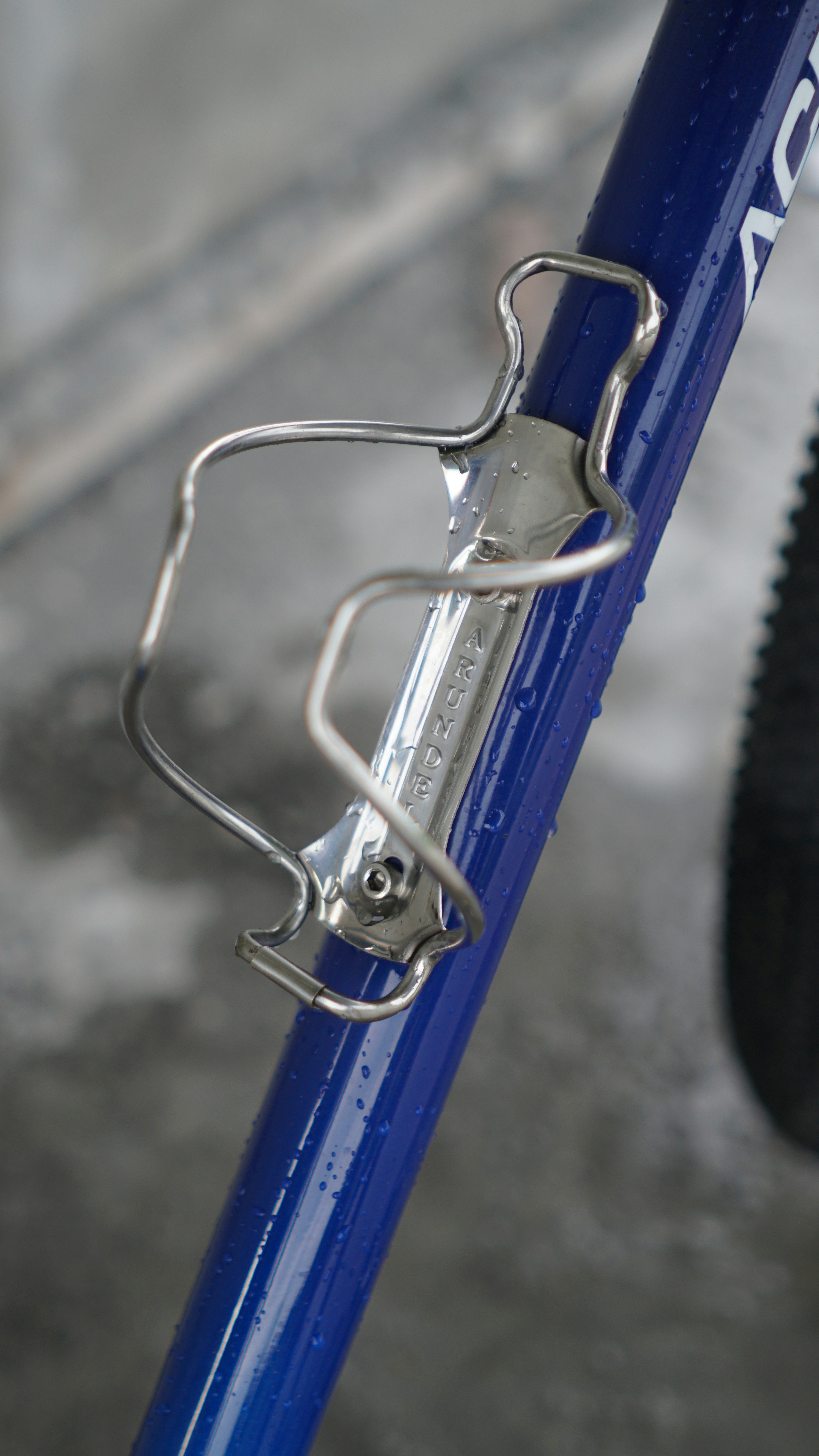 Blue Bicycle Water Bottle Cage in Rain-Damped Light
