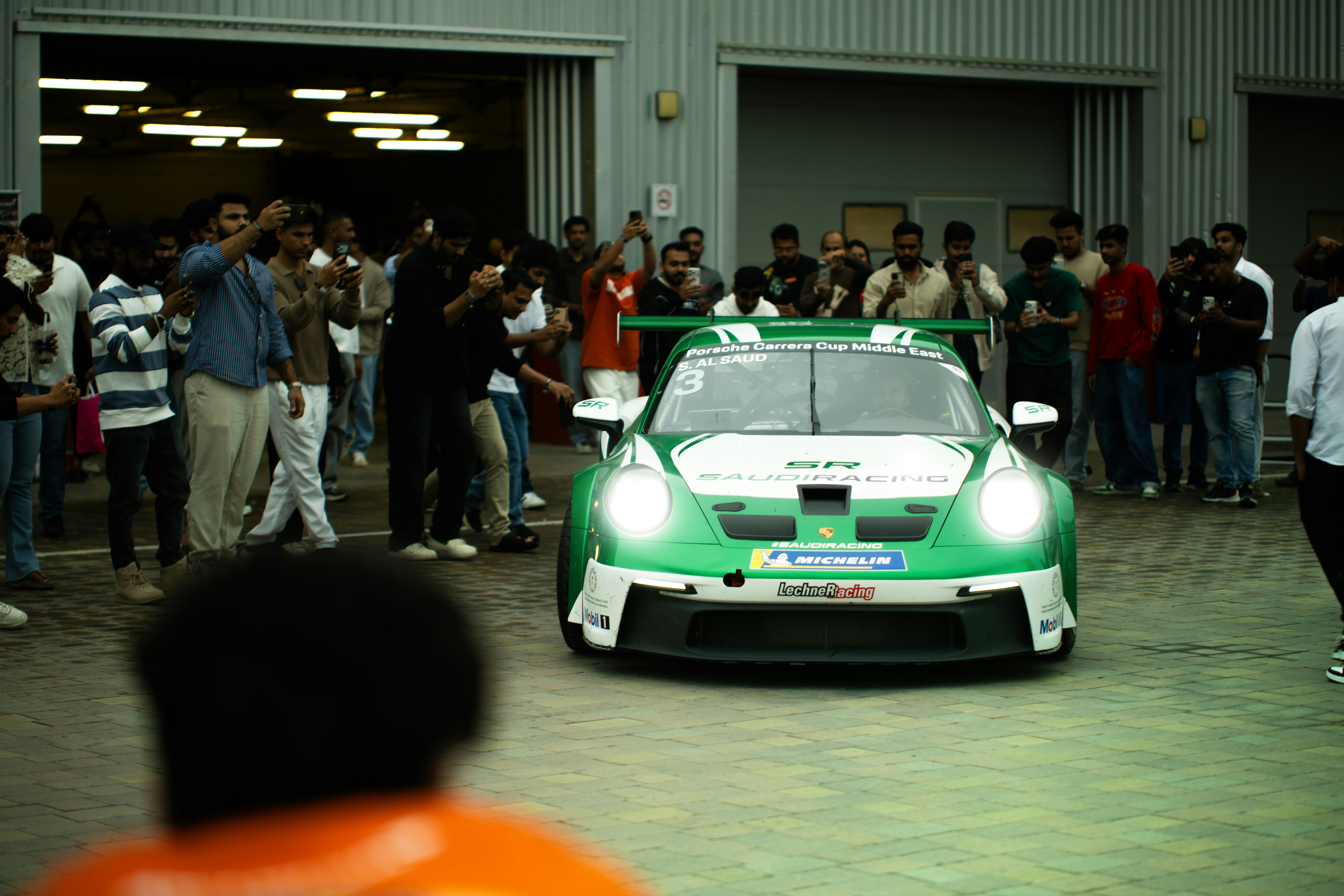Green Racecar Emerges from the Crowd Surge