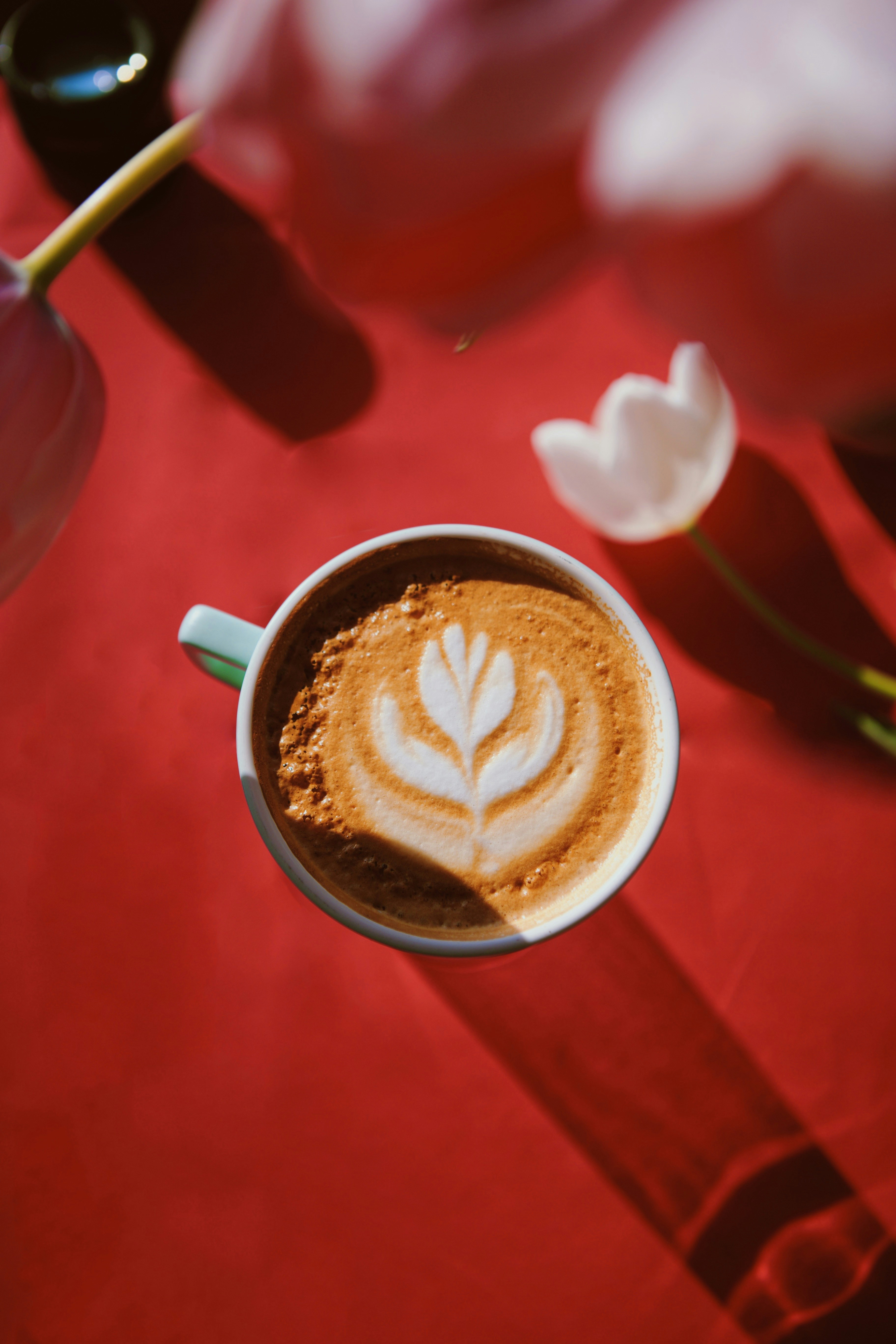 Center Cup: A Latté on a Red Table with Floral Overlays