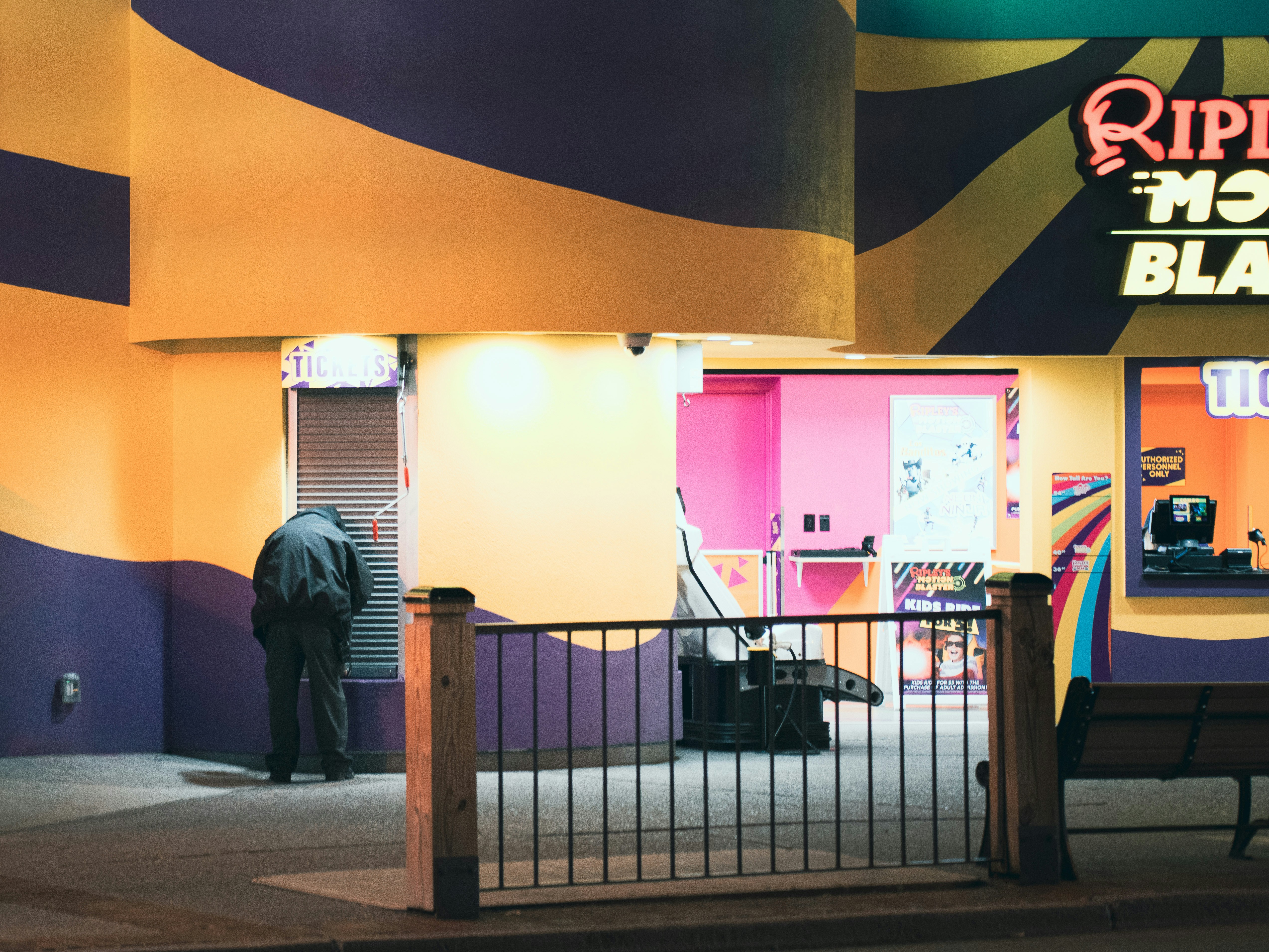 Colorful Arcade Facade and Shaded Bystander at Twilight