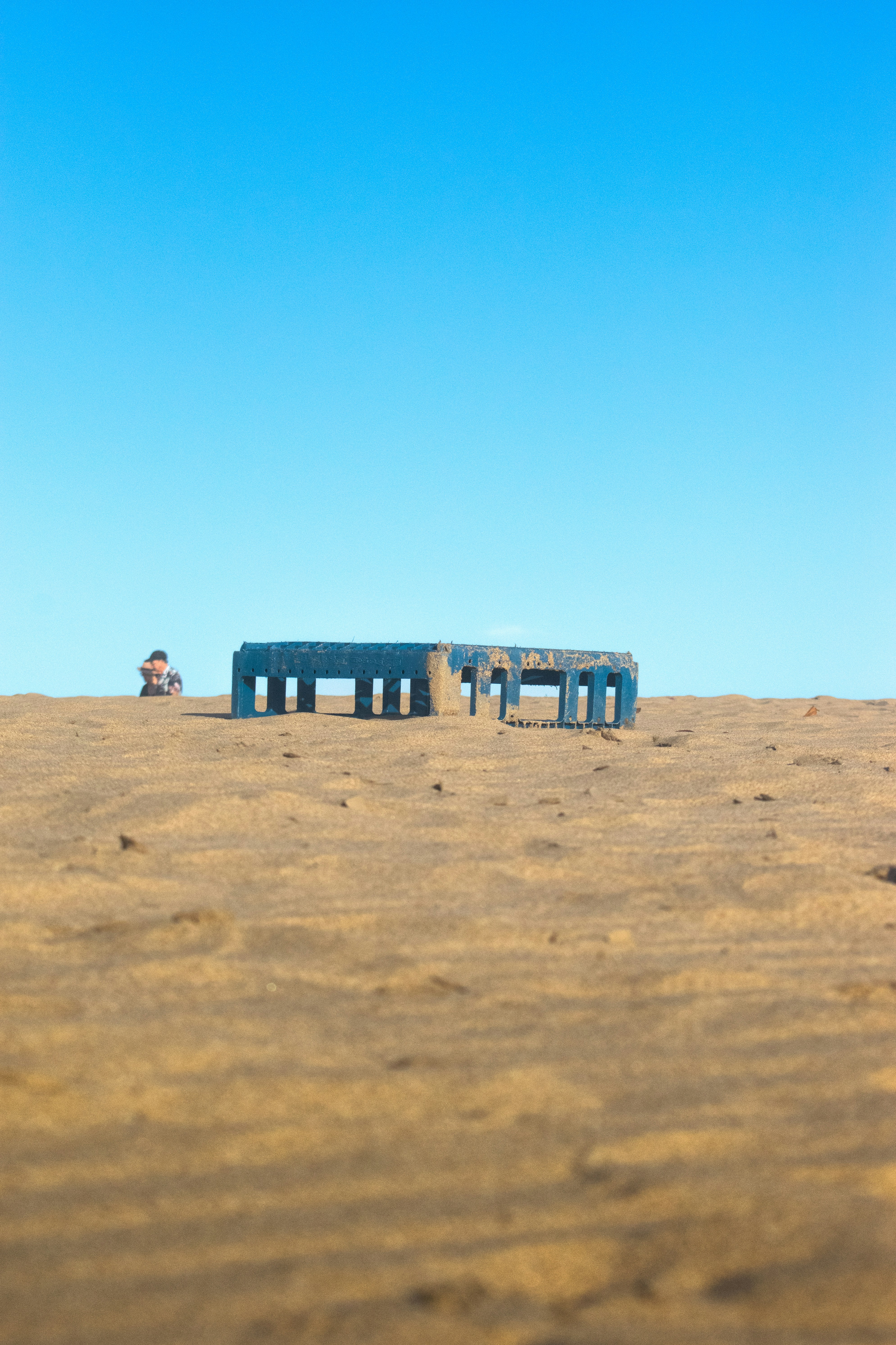 Blue Pier in the Dunes: A Lone Figure and Shelter on an Endless Beach