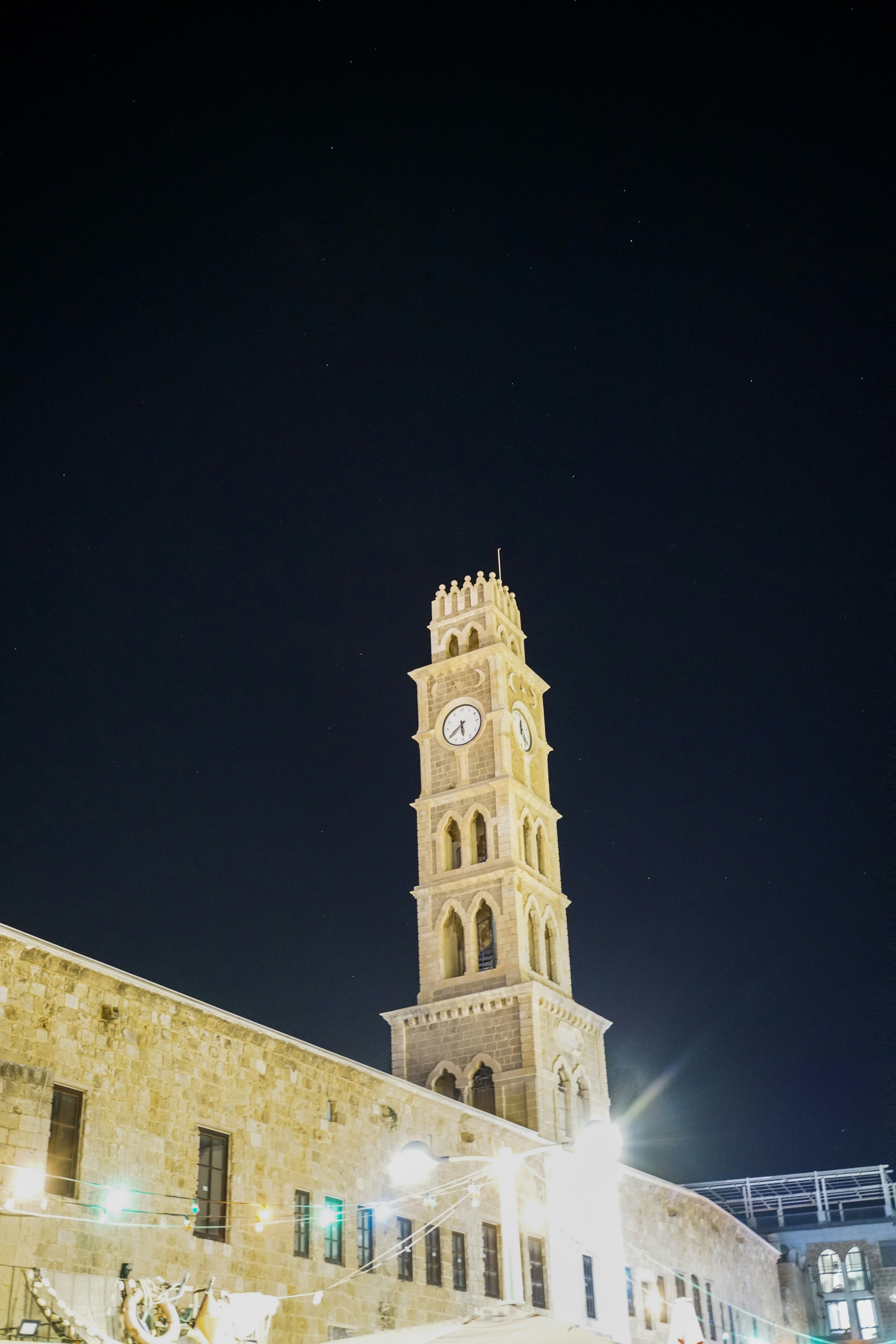 Moonlit Clocktower Rising Above Cobbled Walls