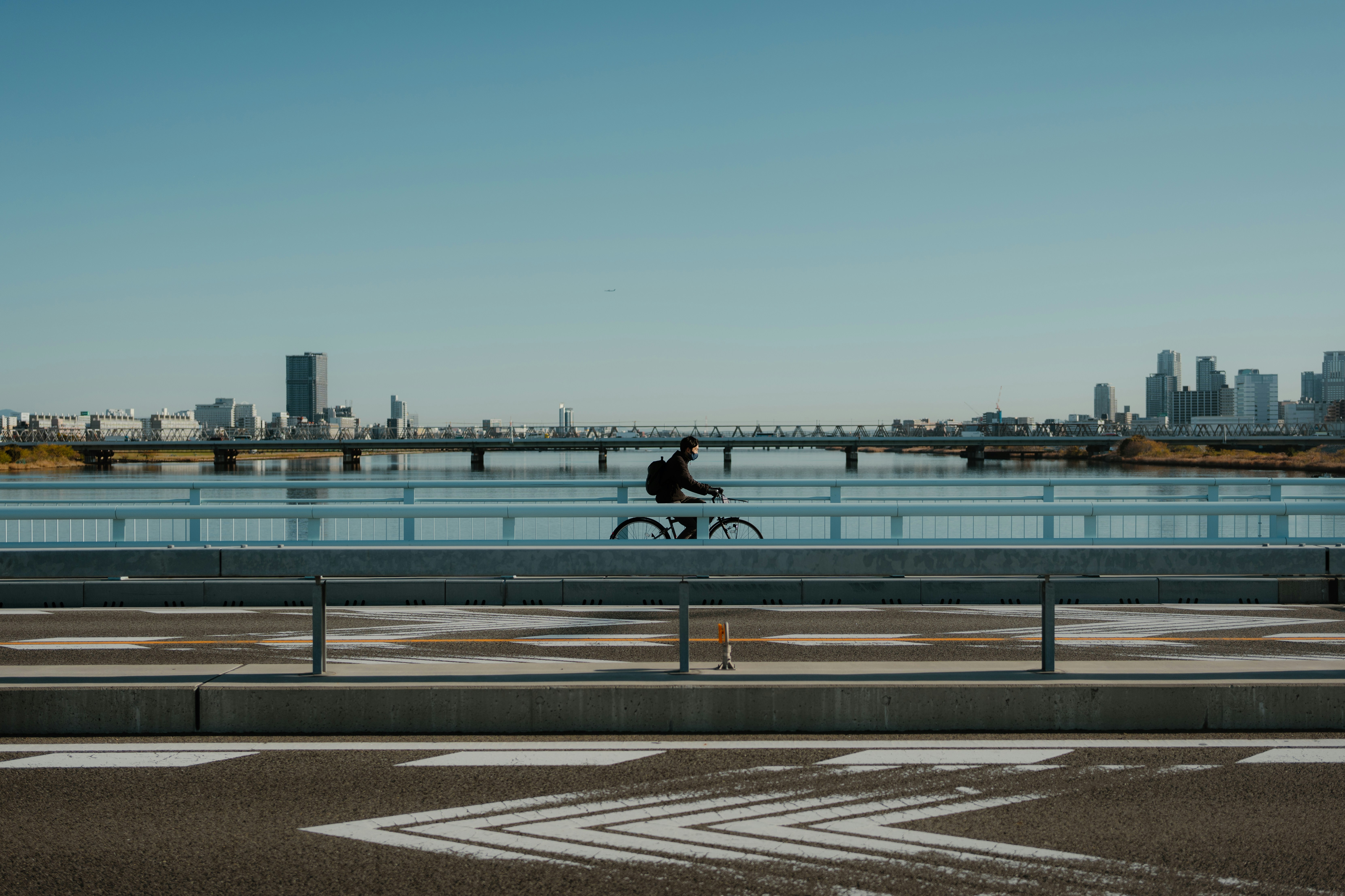 Midday Ride: Cyclist Traces a Quiet Line Across a City Bridge