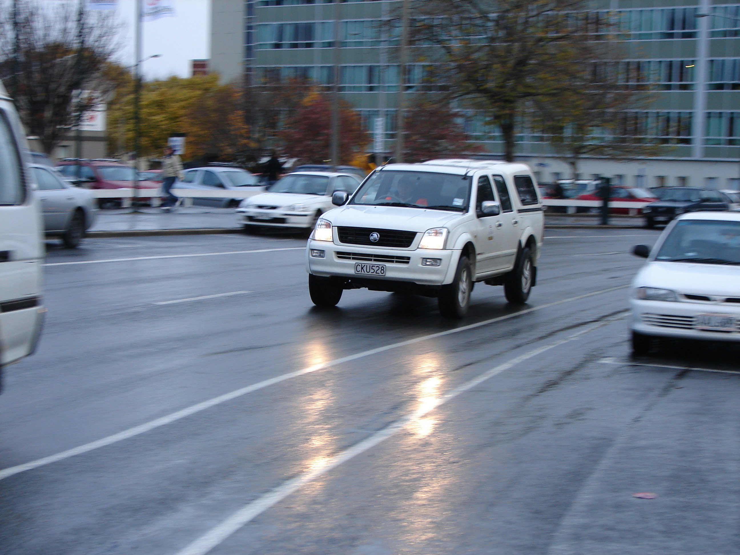 White suv drives on wet city street