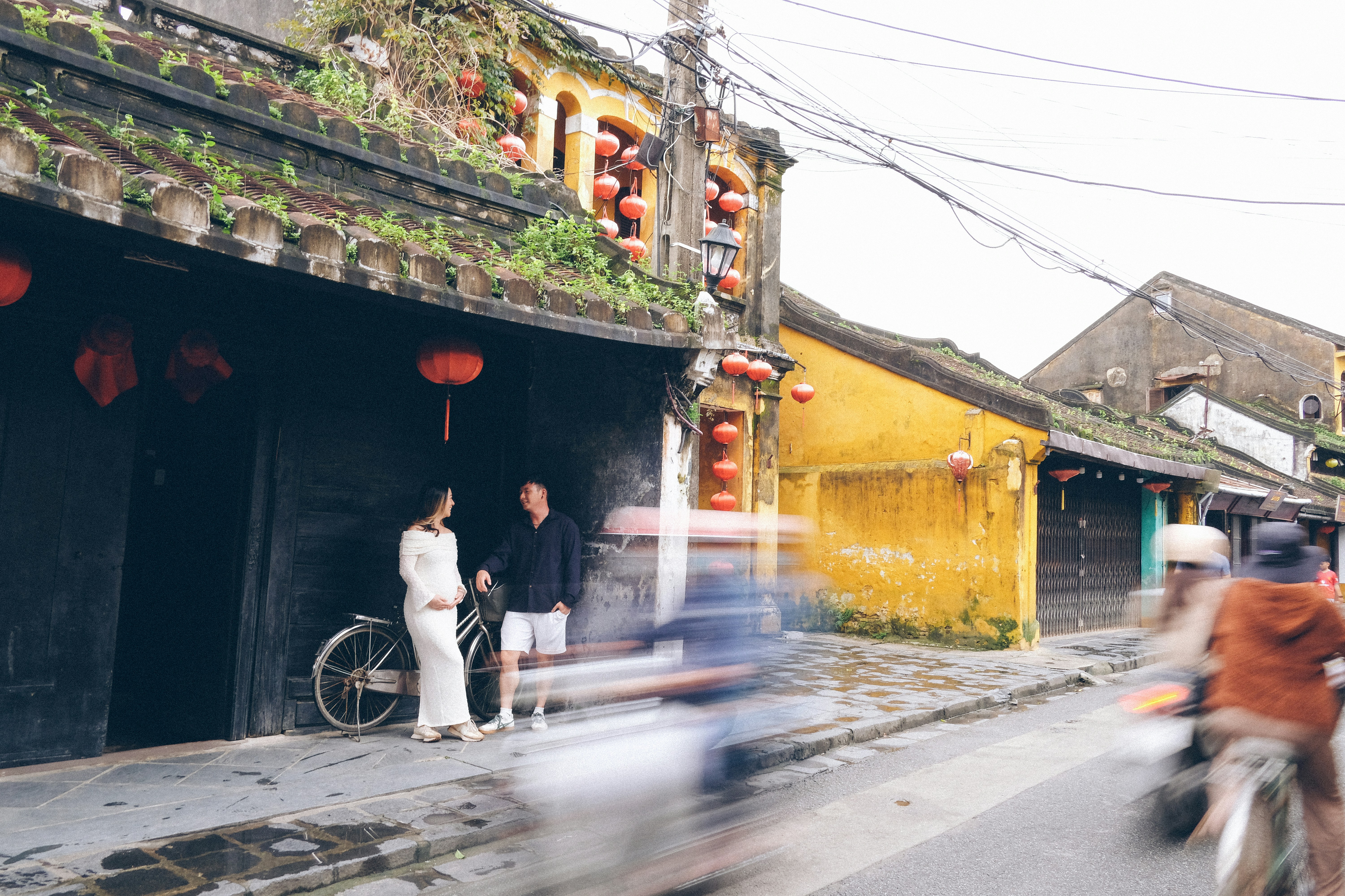 Quiet Moment at a Colorful Lane: A Couple and the Blur of Bikes