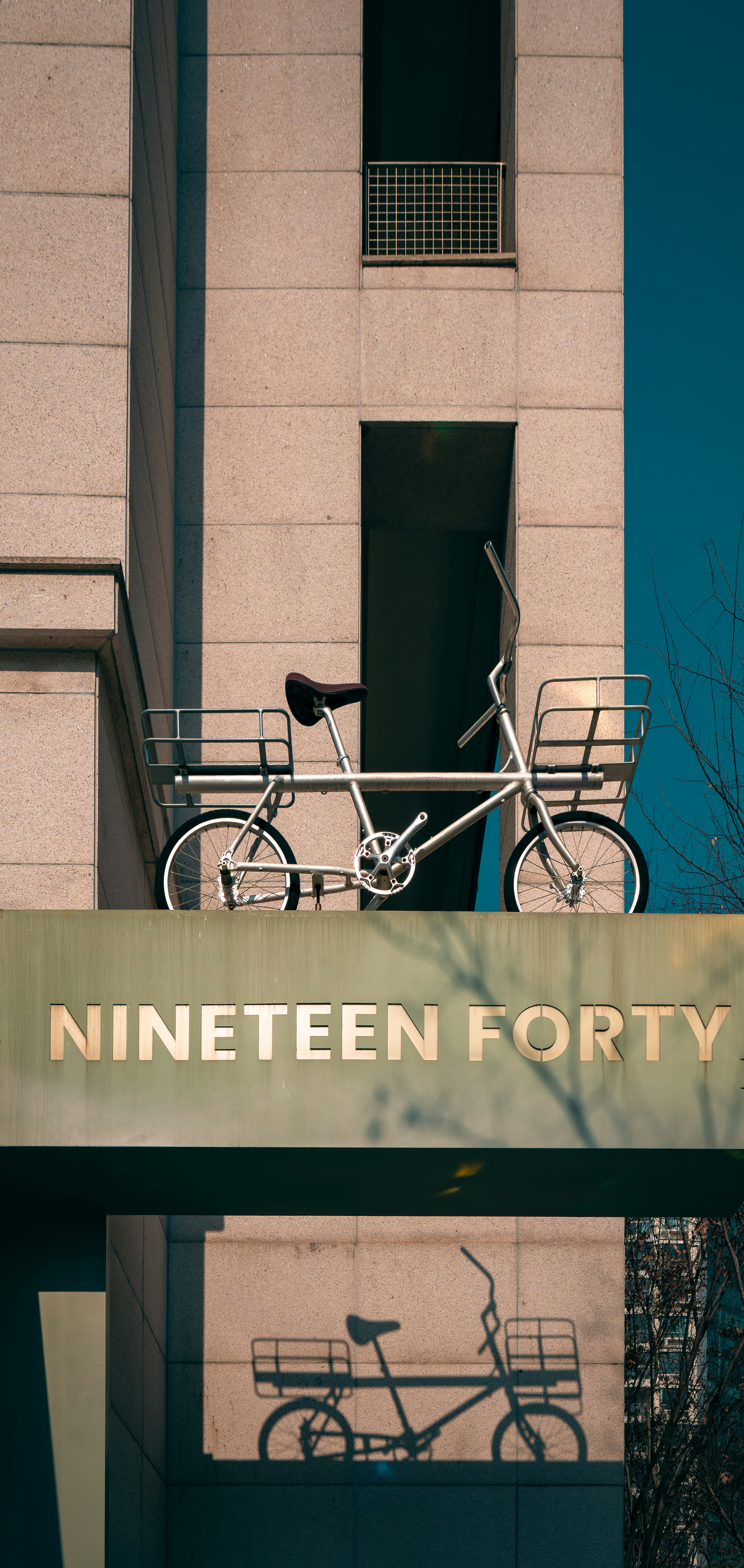 Bike on a ledge: a bold architectural portrait of NINETEEN FORTY signage