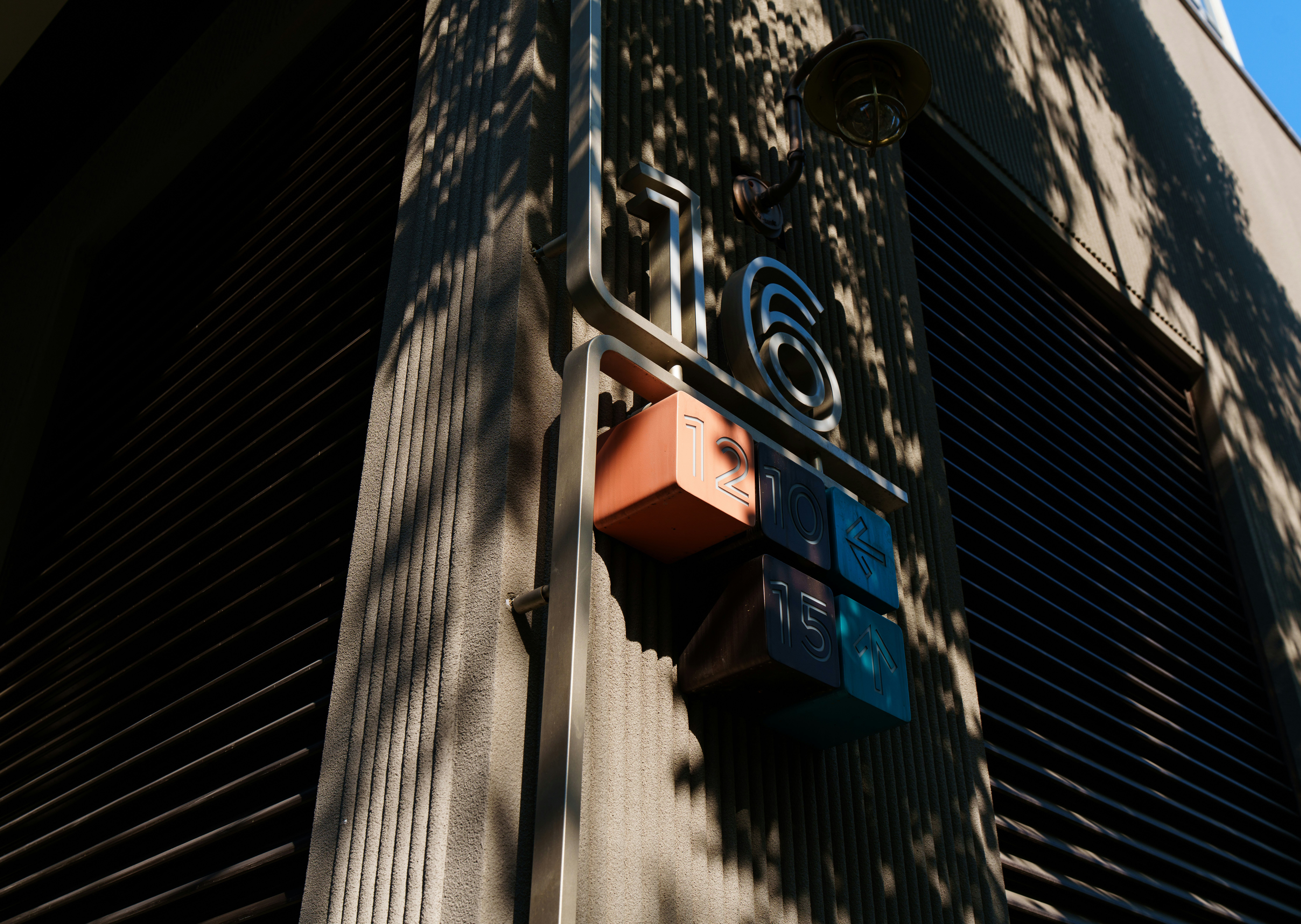 Shadows on a House Number: A Quiet Moment with Colorful Mailboxes