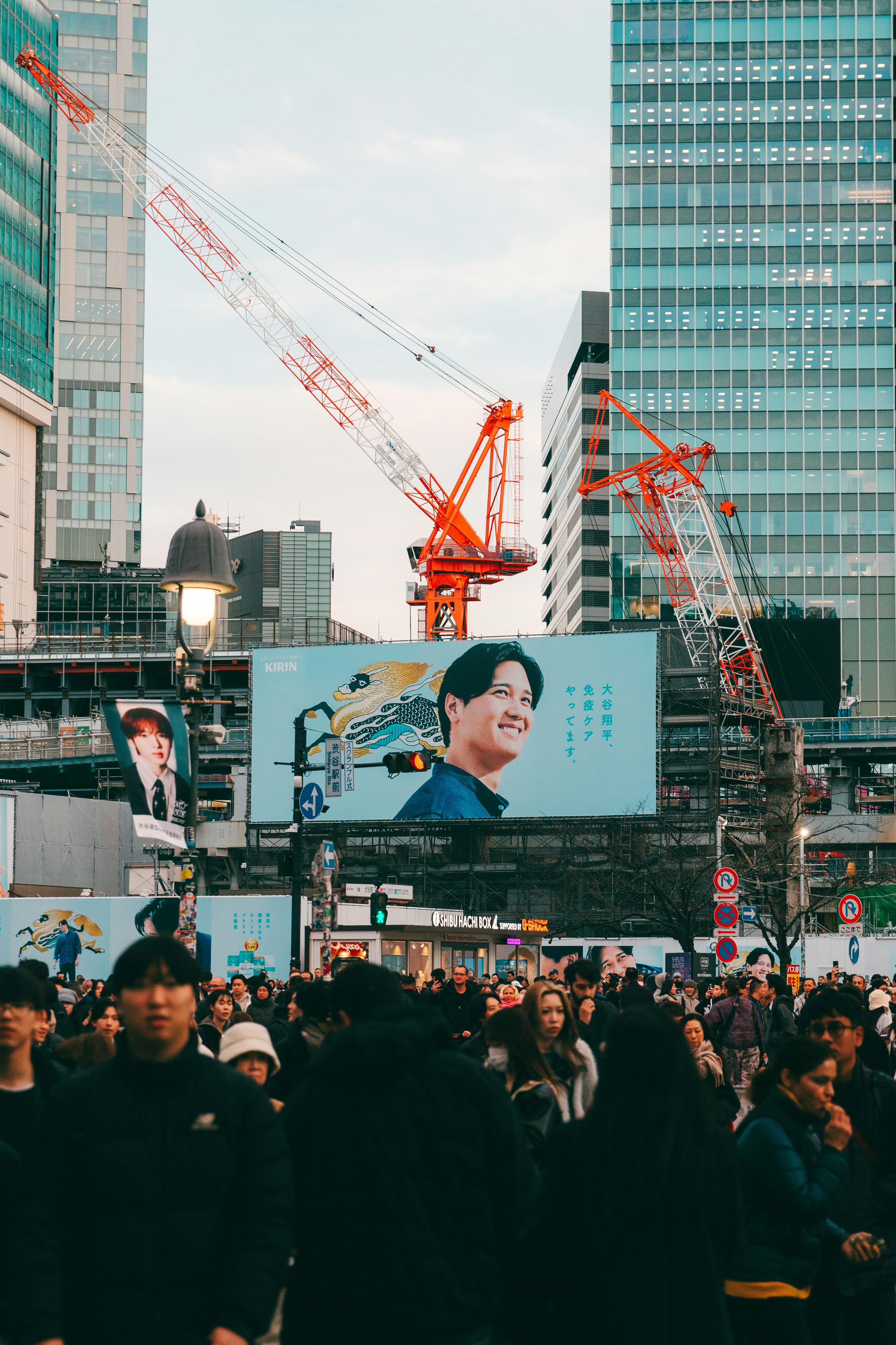 City Pulse Under Construction: A Billboard Portrait Over a Crowded Street