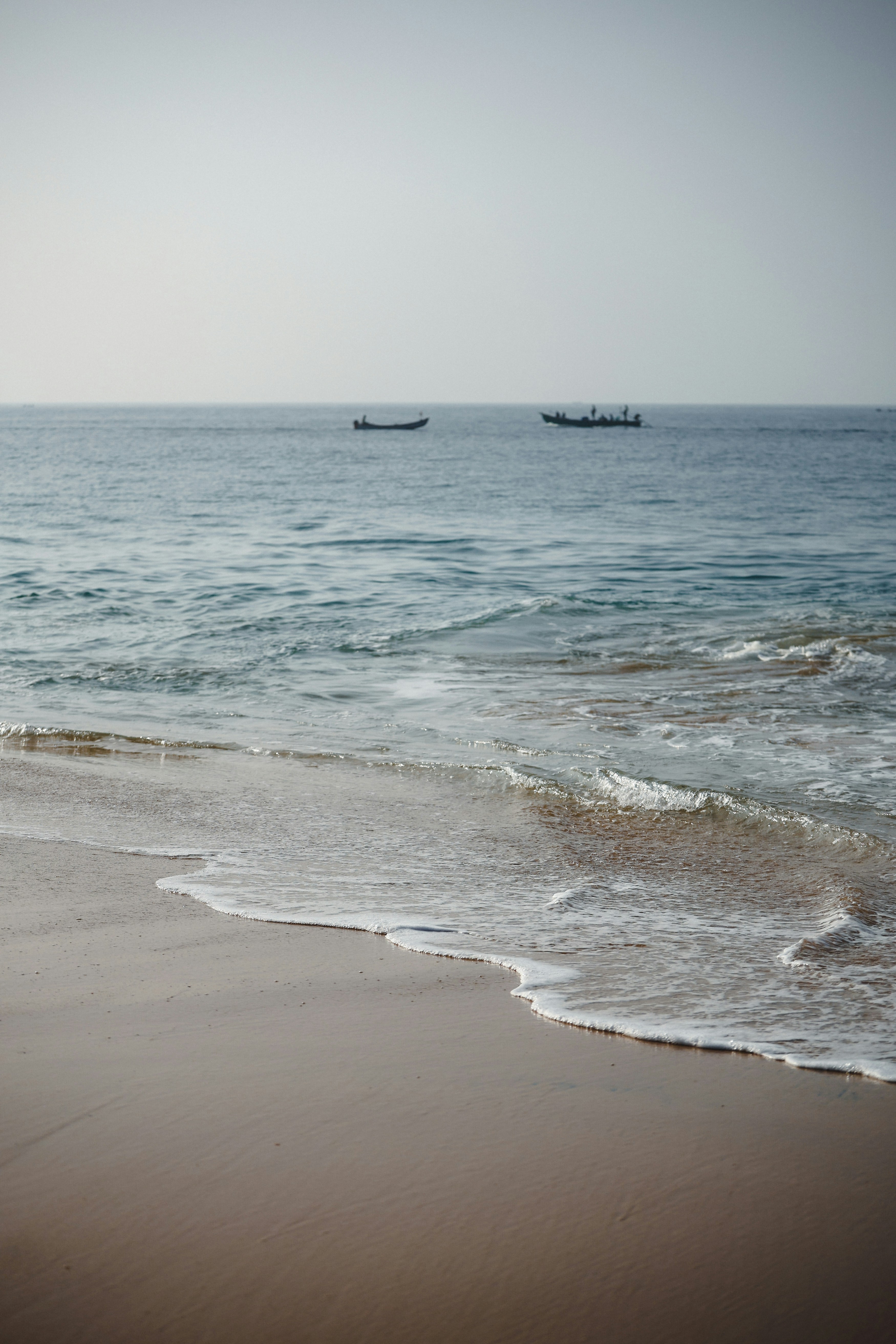 Distant Boats on a Quiet Sea at Dawn