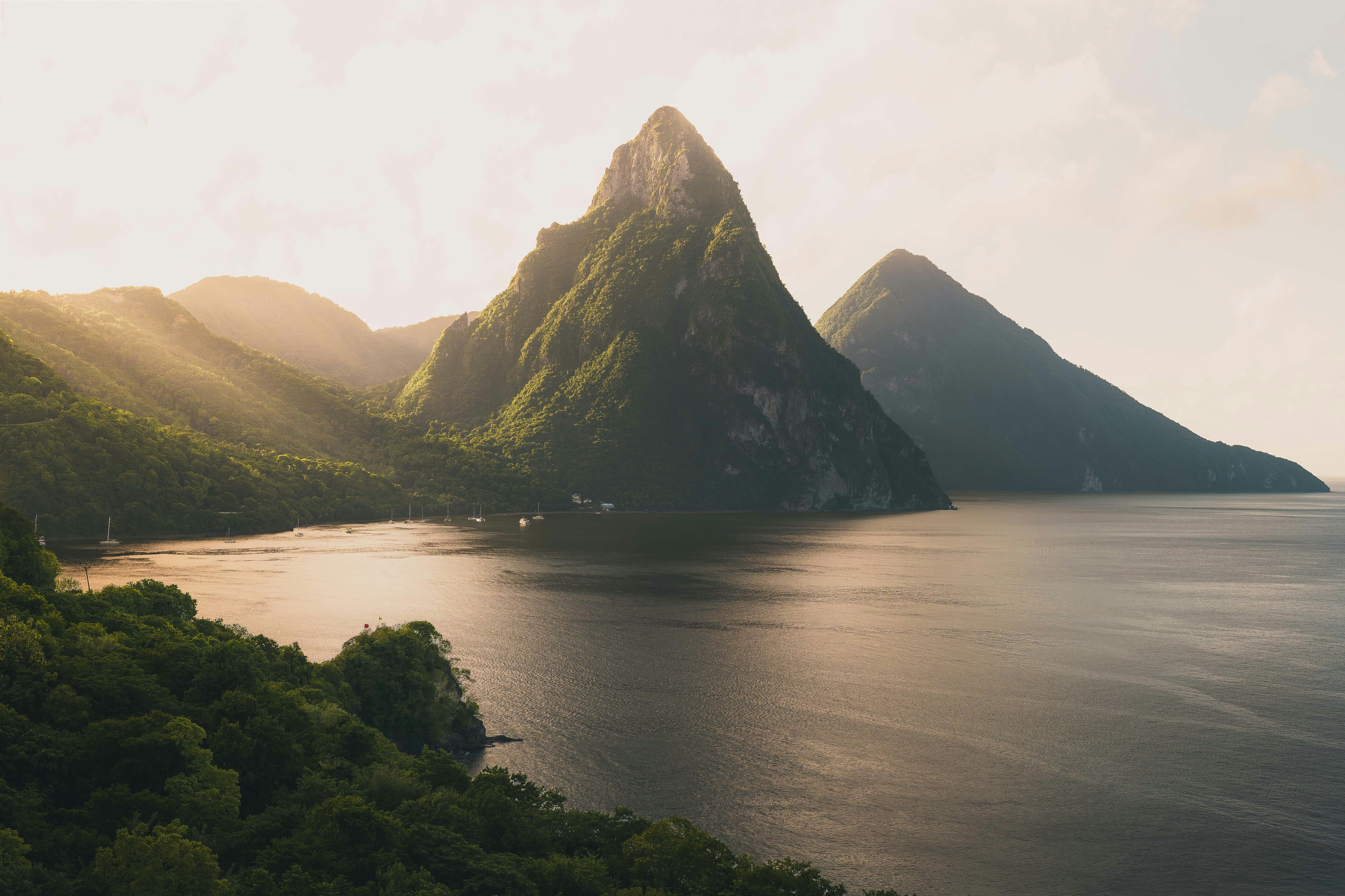 Twin Peak Serenade: Sunlit Cove Beneath Verdant Slopes