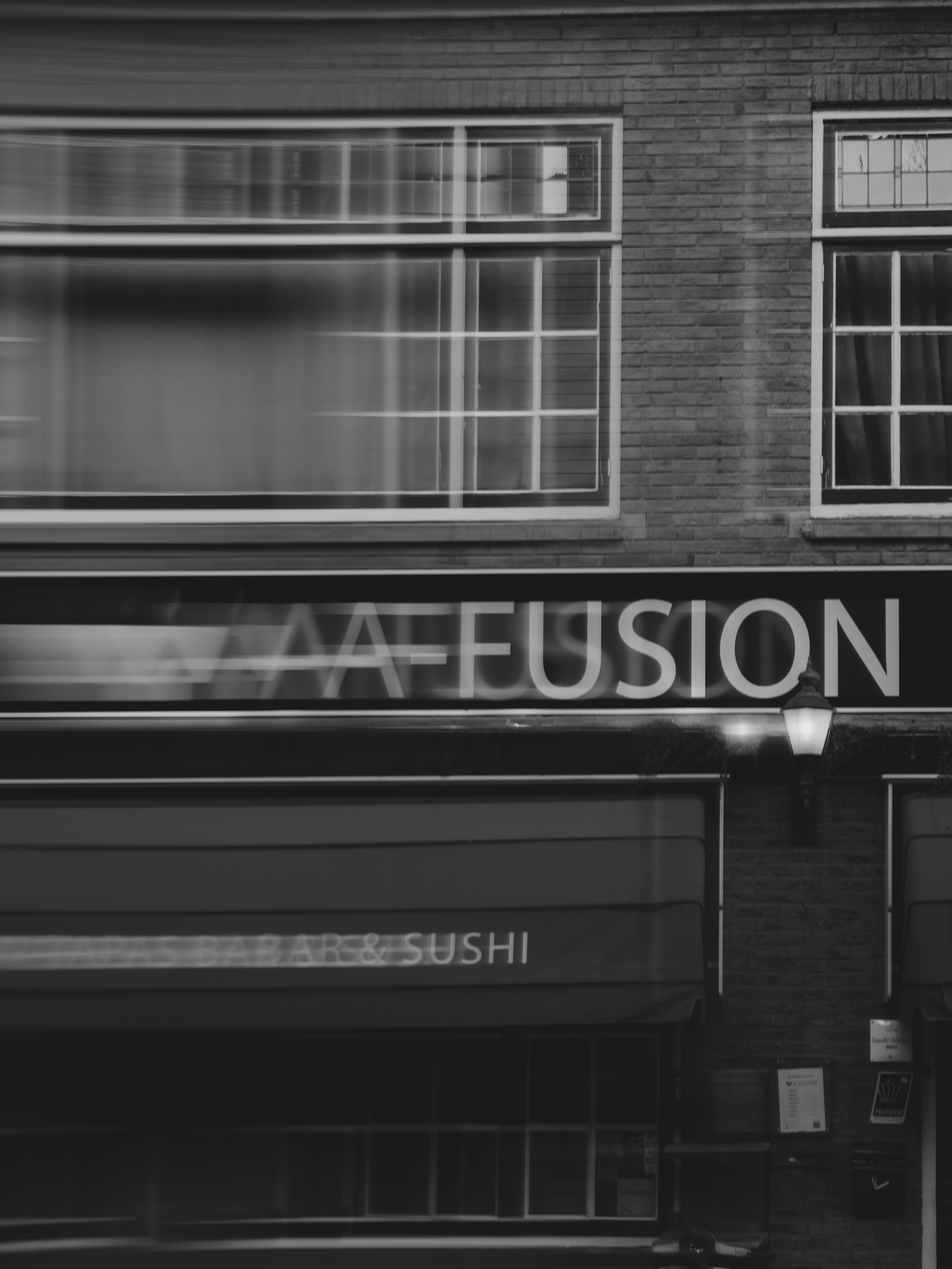 Blurred storefront sign of fusion over a dim street