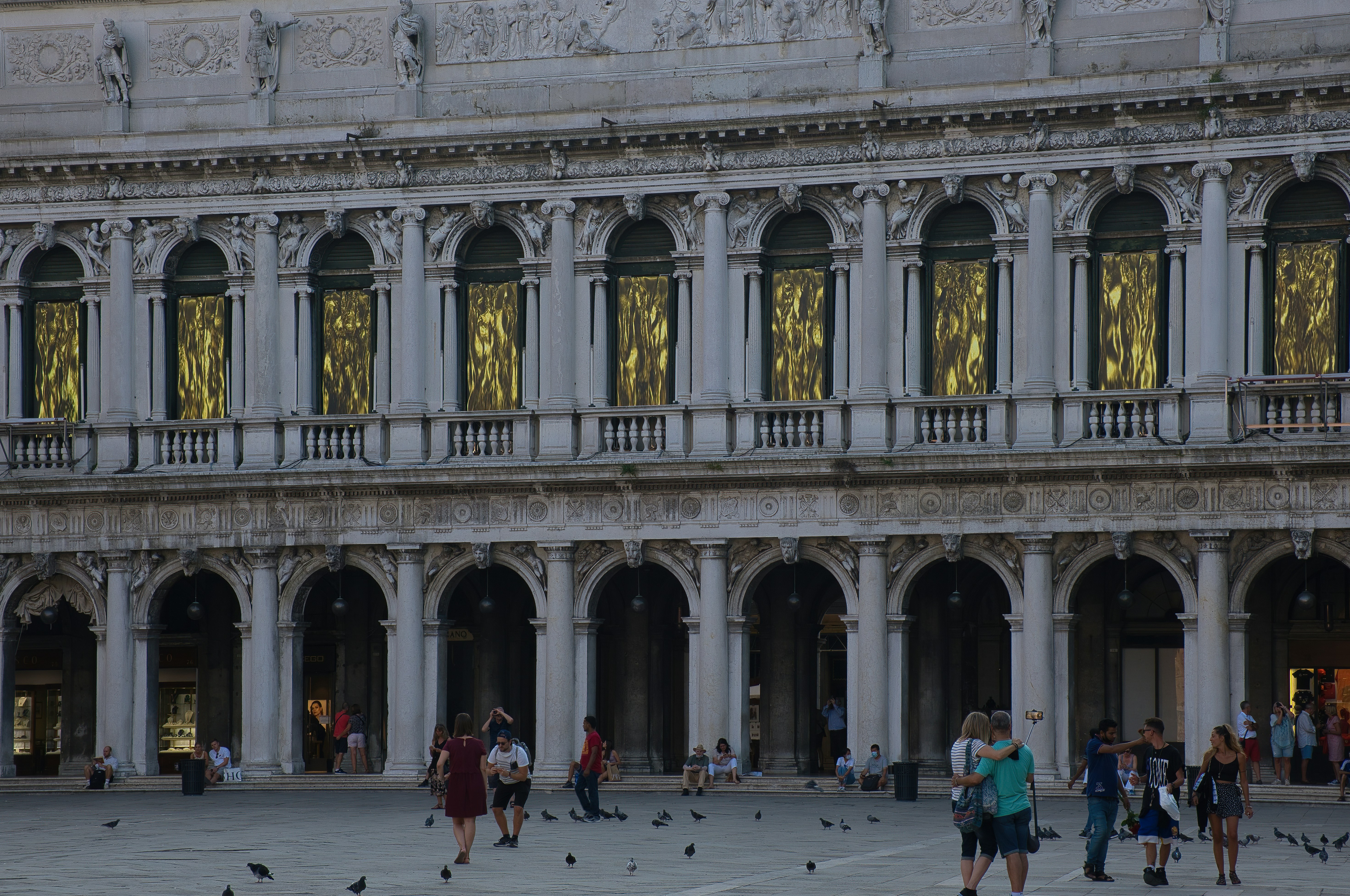 Columns and Courtyard Echoes: People in Front of a Historic Arcade