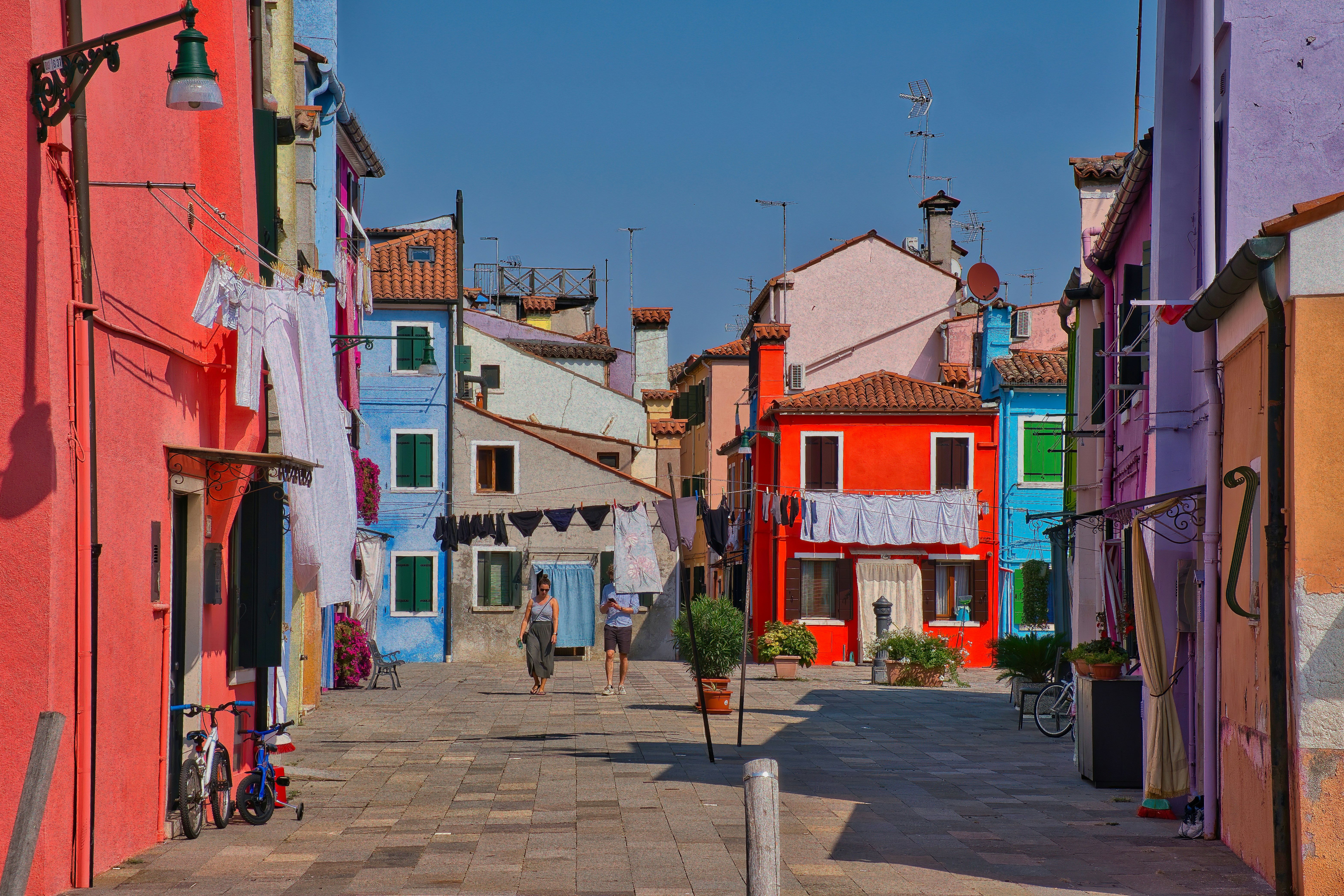 Vivid Alleyway: A Palette of Painted Homes and Quiet Strollers