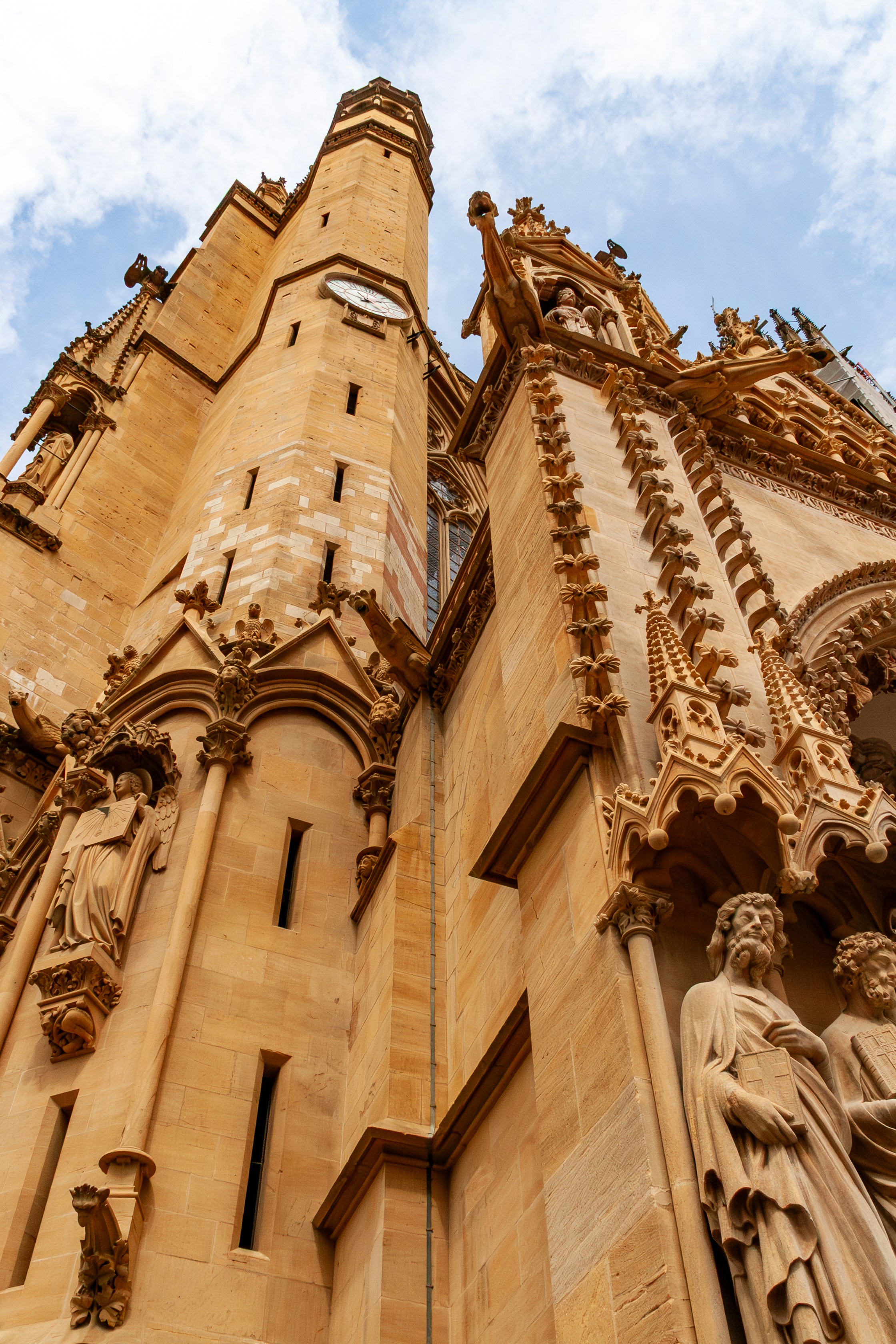 Gothic Facade Ascending: Stone Carvings Against a Sky-Blue Backdrop