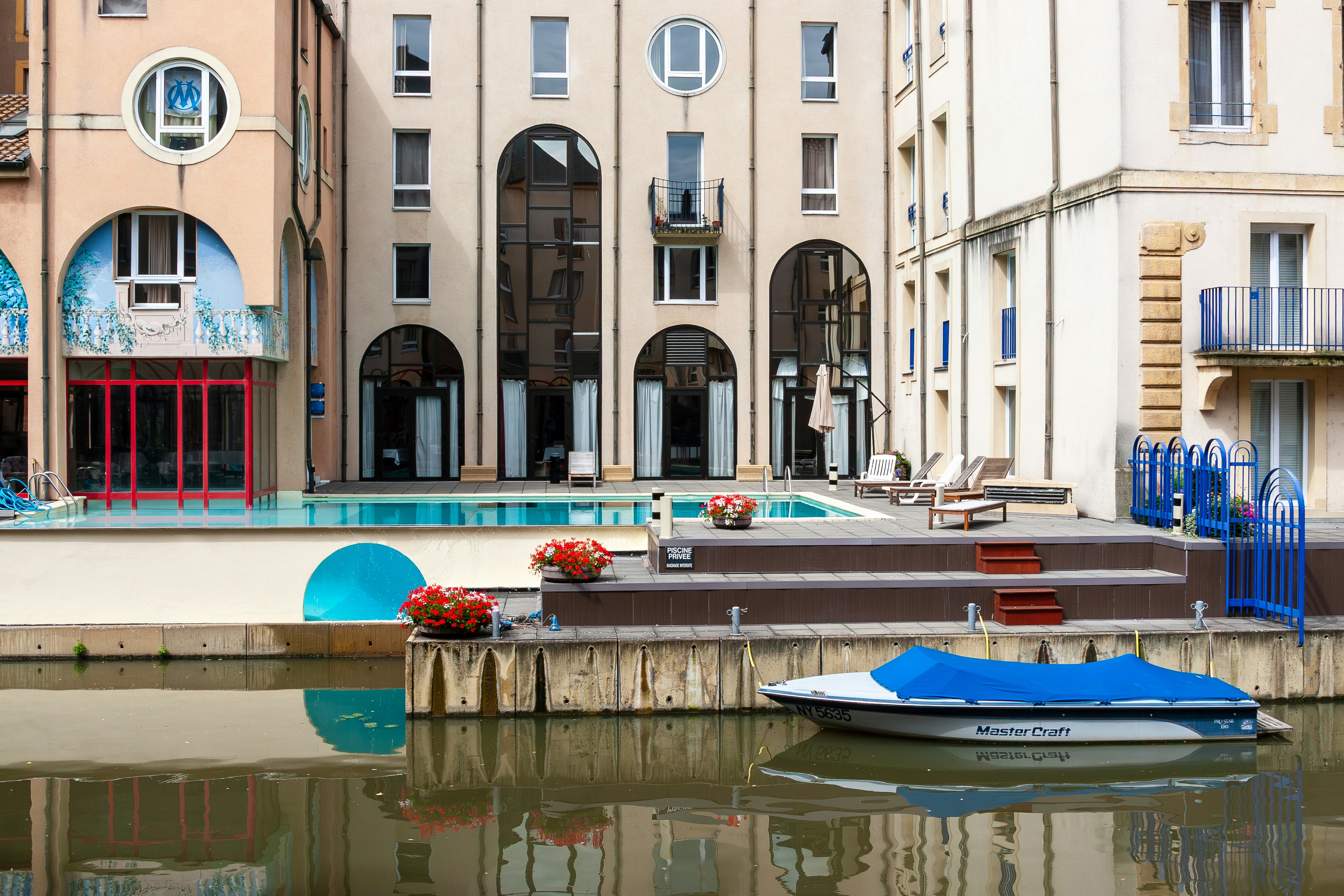 Waterfront Courtyard: Boats, Arches, and Colorful Reflections