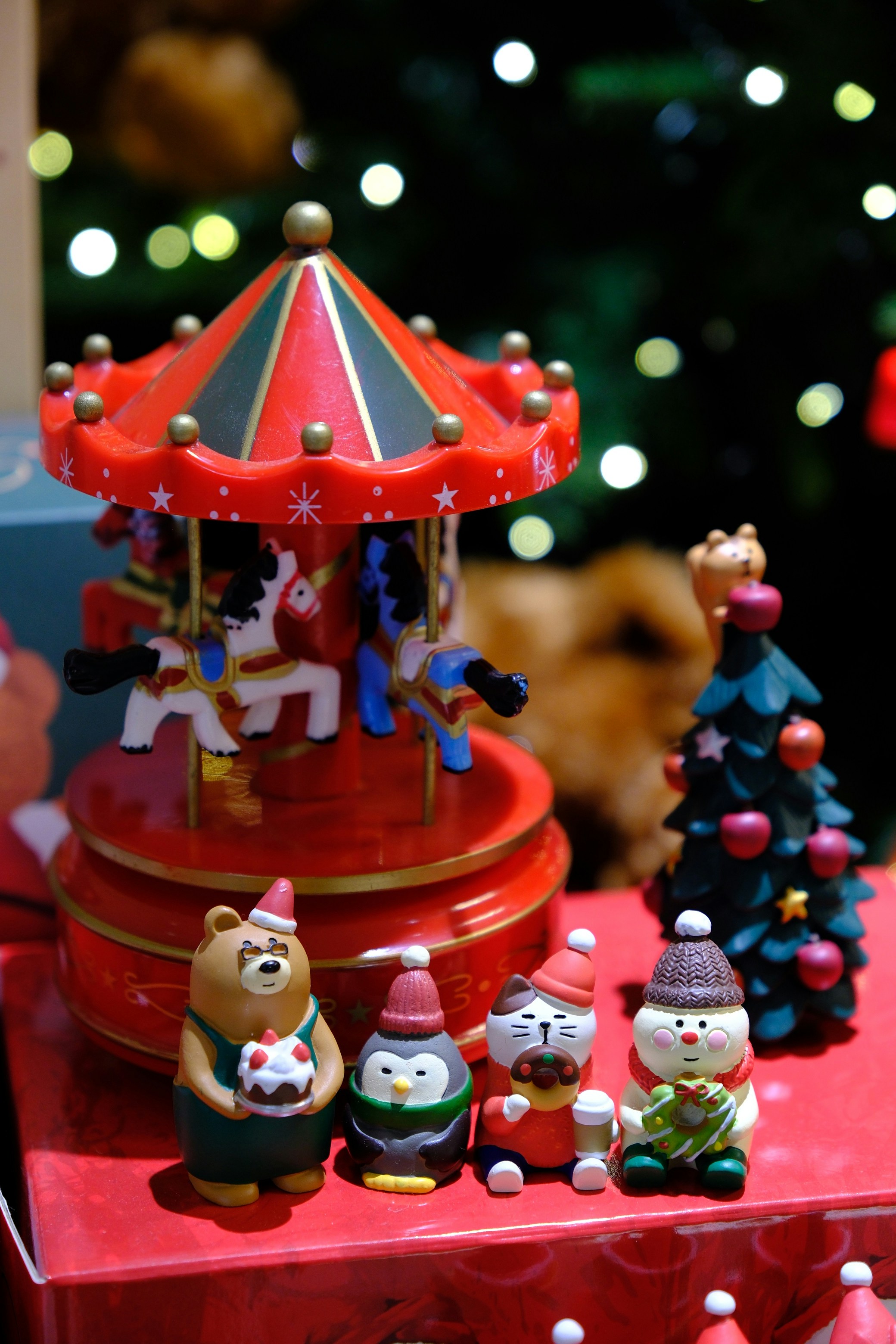 Tiny Christmas Parade: Smiling Figurines Stand Guard by a Carousel