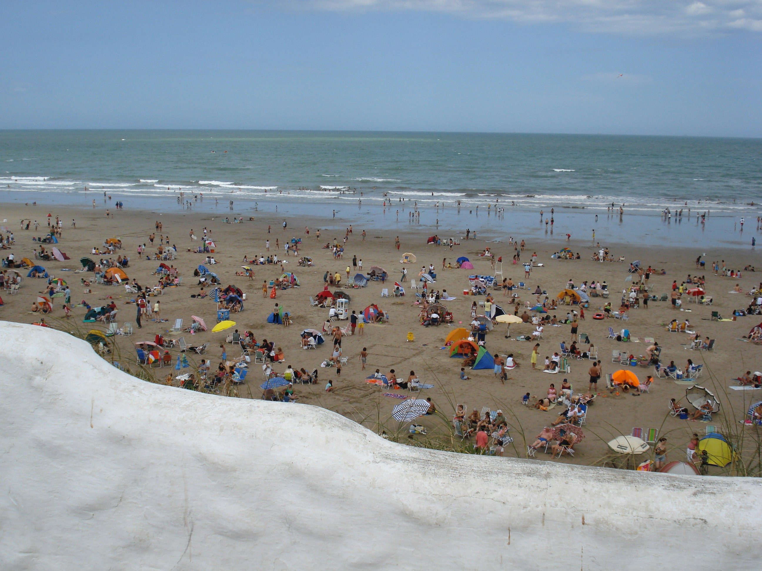 Crowded beach with many people and colorful umbrellas