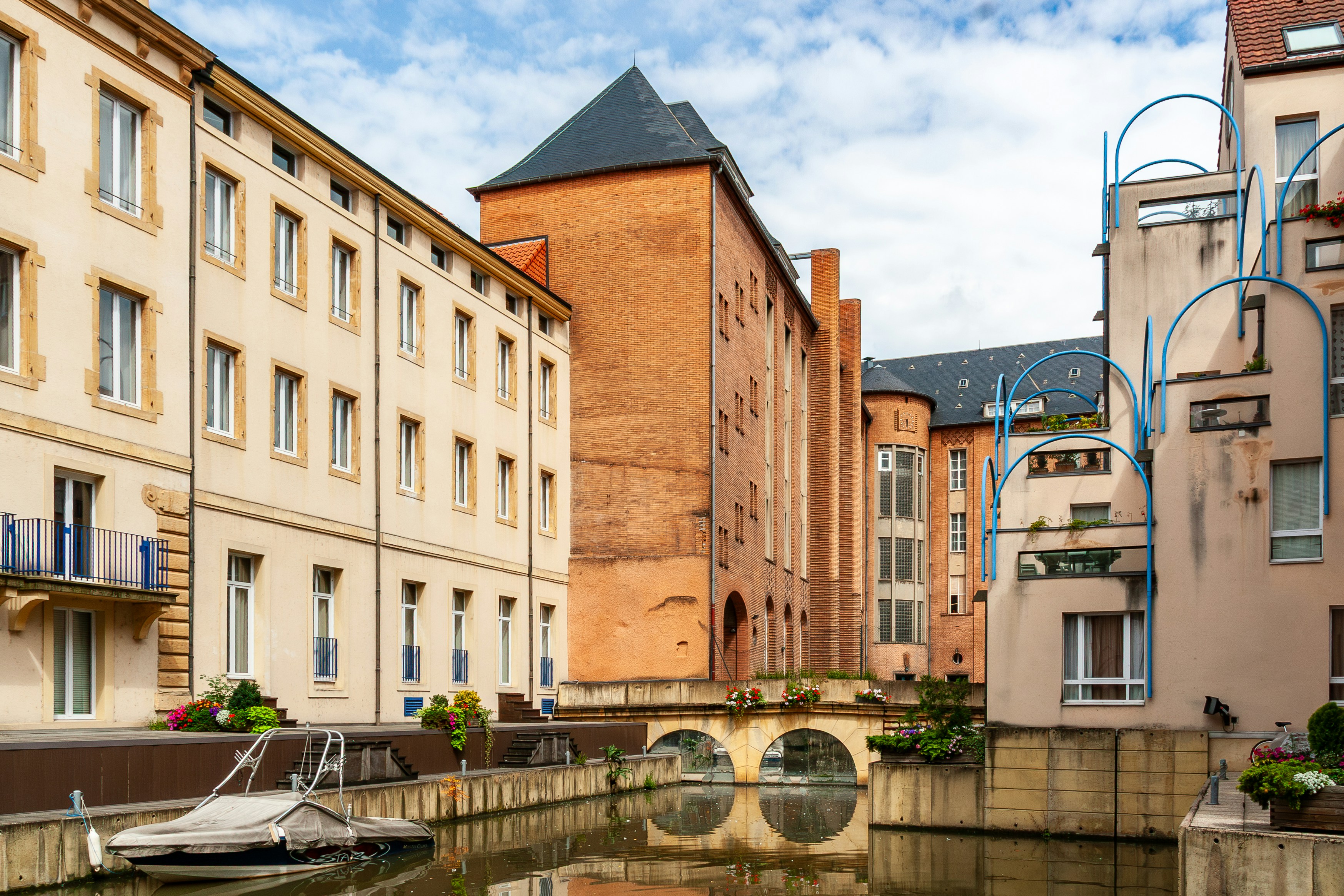 Brick Arches and Canal: A Quiet Cityscape Under a Bright Sky