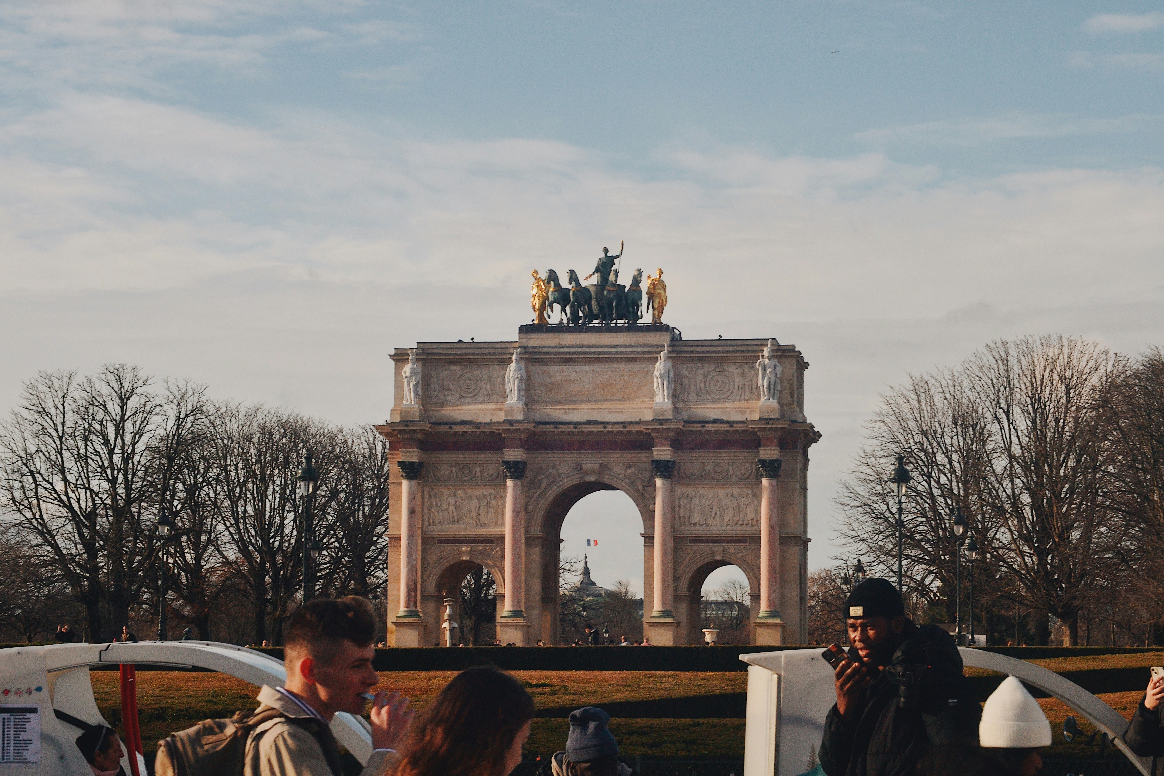 Archway of Victory: People and Sculpted Quadriga Framed by a Park Approach