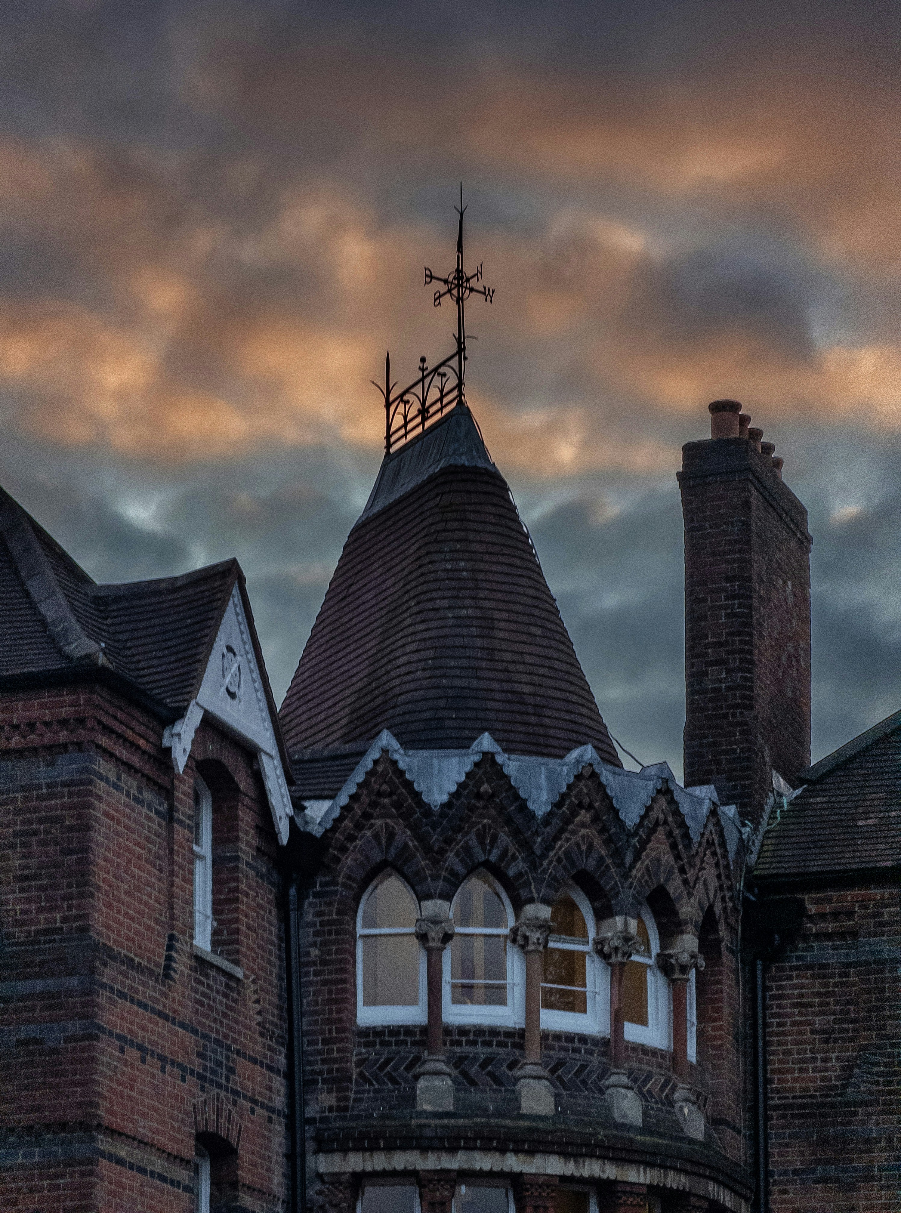 Gothic Rooftops at Sunset: A Brickwork Spine Under Darkening Skies