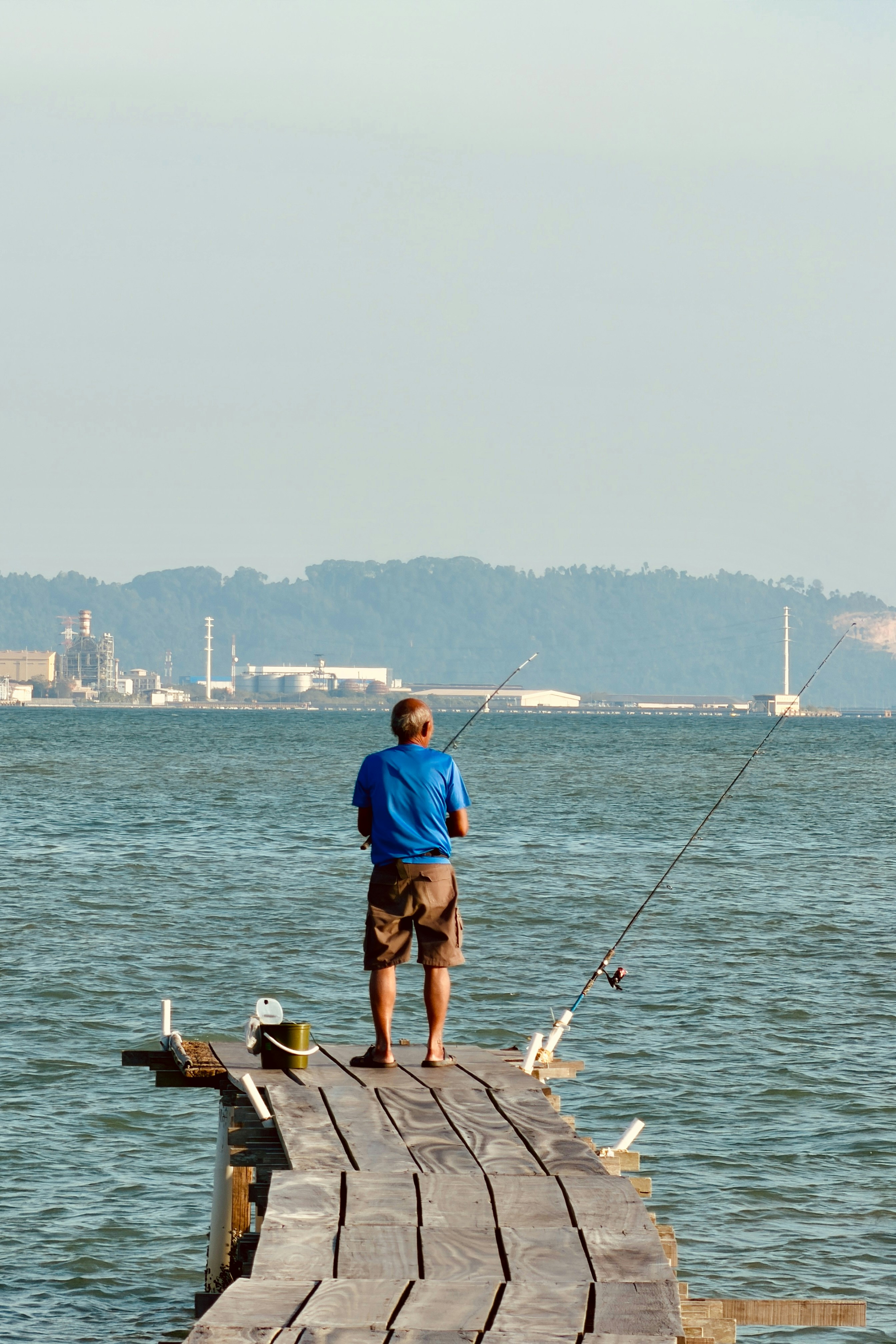 Fishing at the End of the Pier: A Calm Waterfront Moment