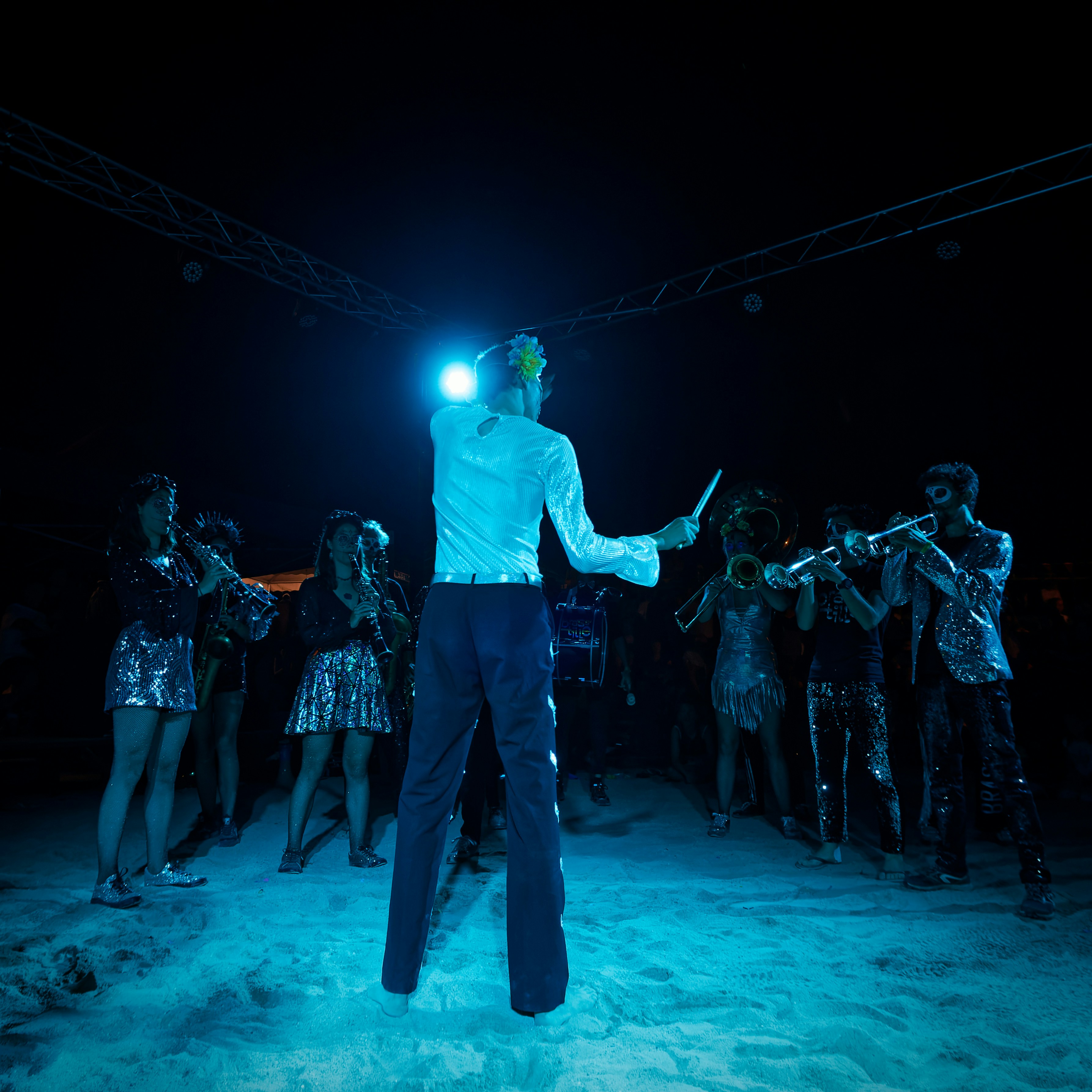 Blue Spotlight Conductor Leading a Neon-Soaked Beach Party