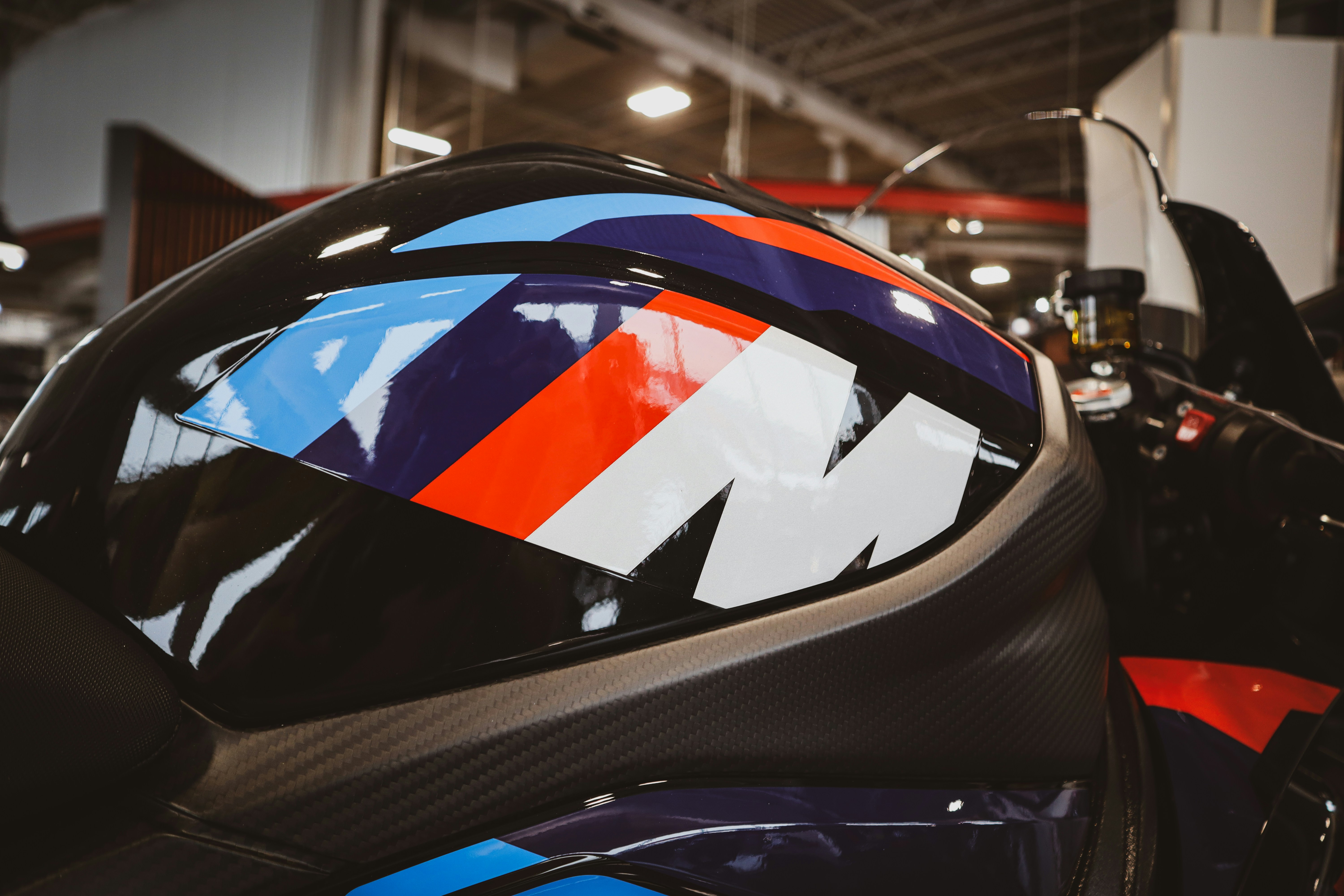 M-Color Crest: Close-Up of a Racing Helmet Logo on Carbon Fiber