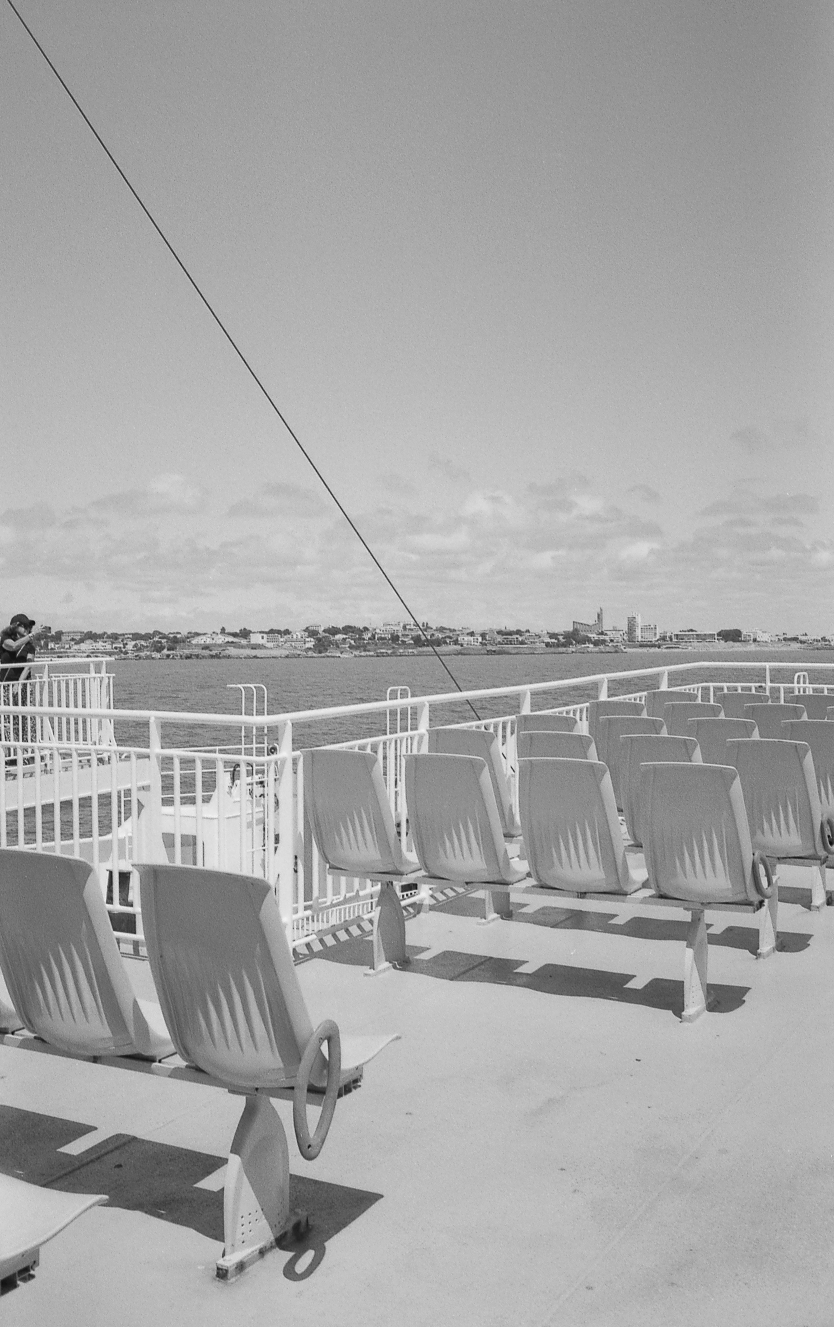 Silent Shoreline of Seats: A Maritime Pier in Monochrome