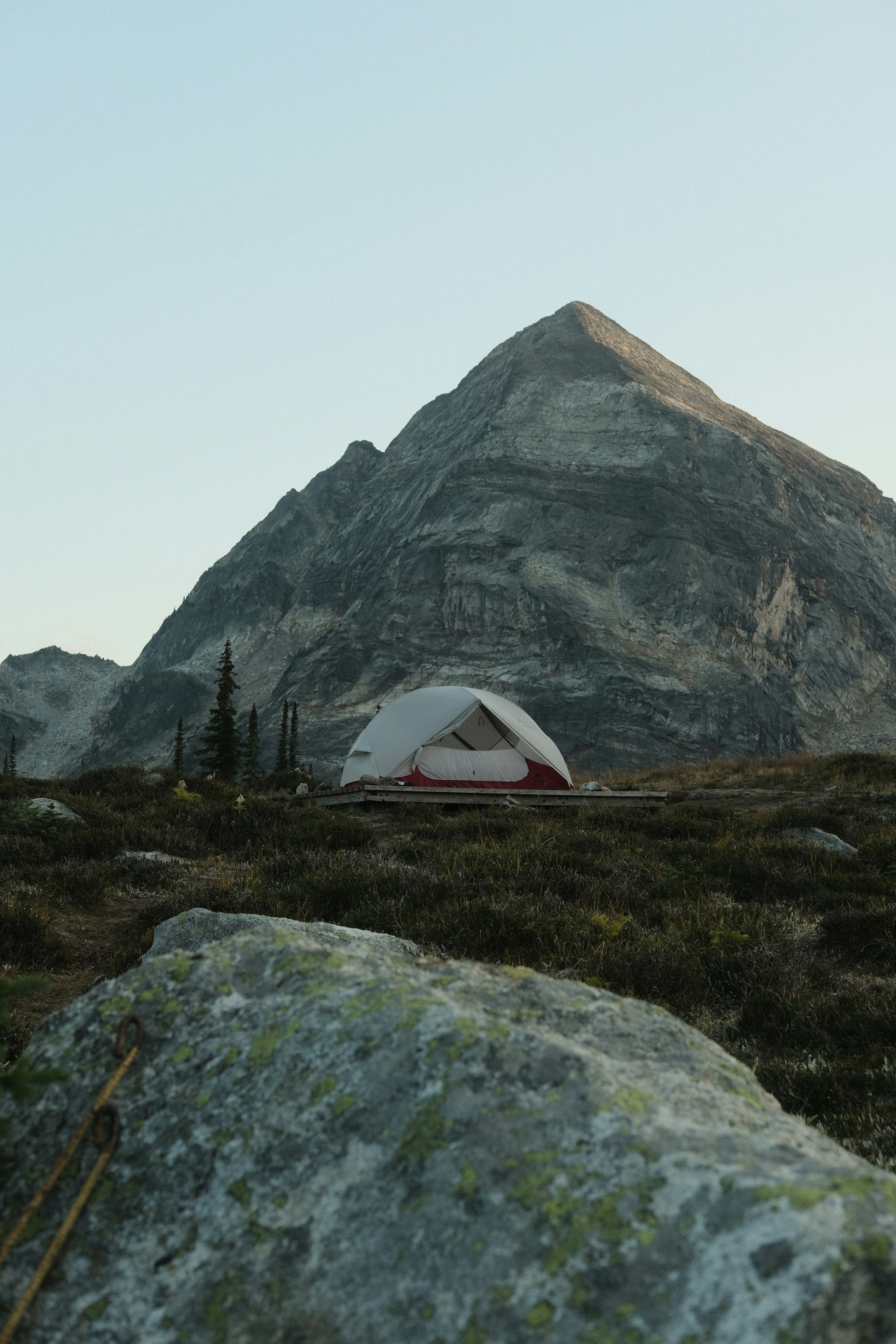 Tent on a High Alpine Plain Beneath a Steep Mountain