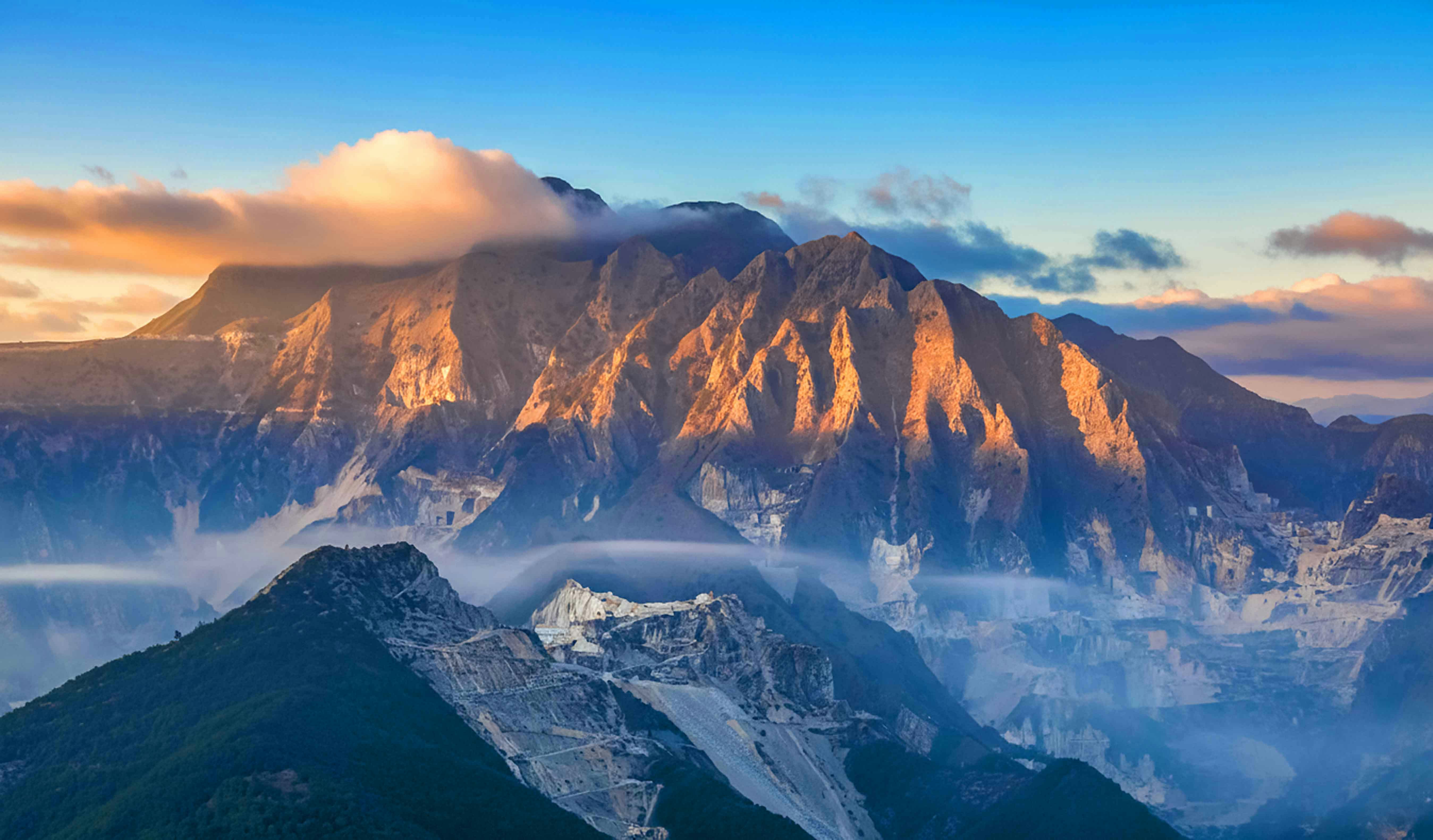 Sunlit Summit: Alpine Peaks Rise from a Misty Crest