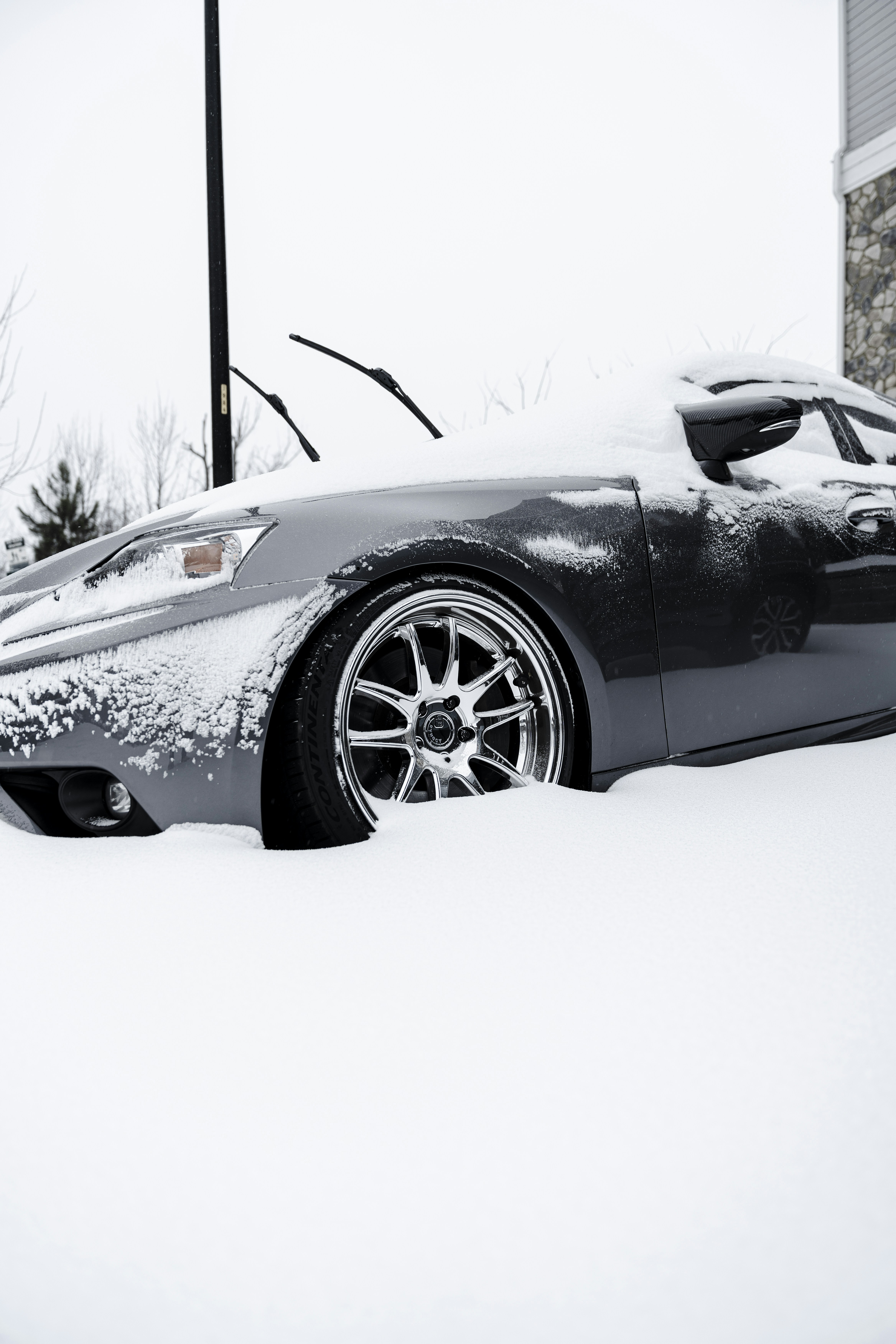 Snowbound Stance: A Silver Car Emerges from the Quiet White Drift