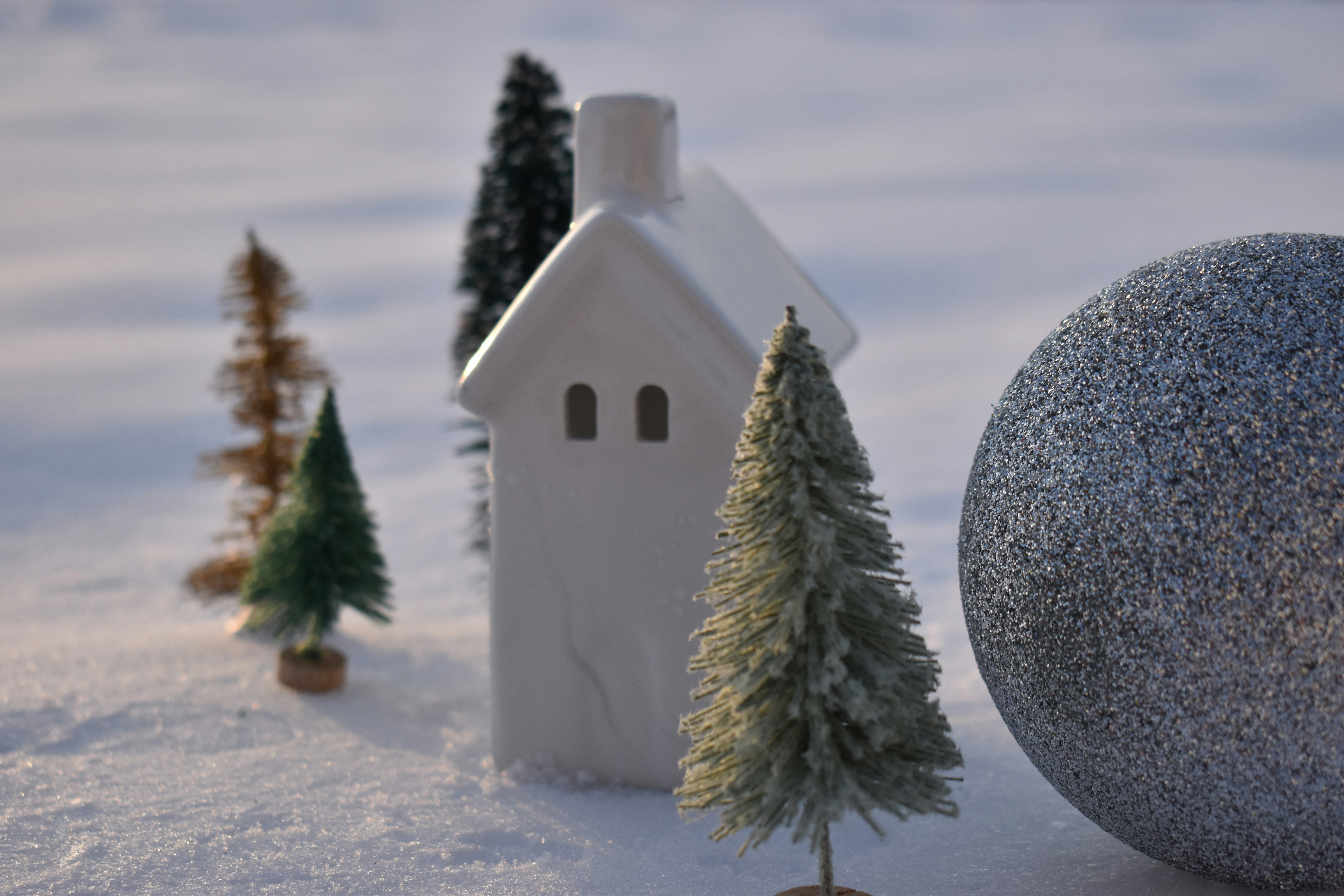Miniature Winter Homestead Beside a Sparkly Ornament