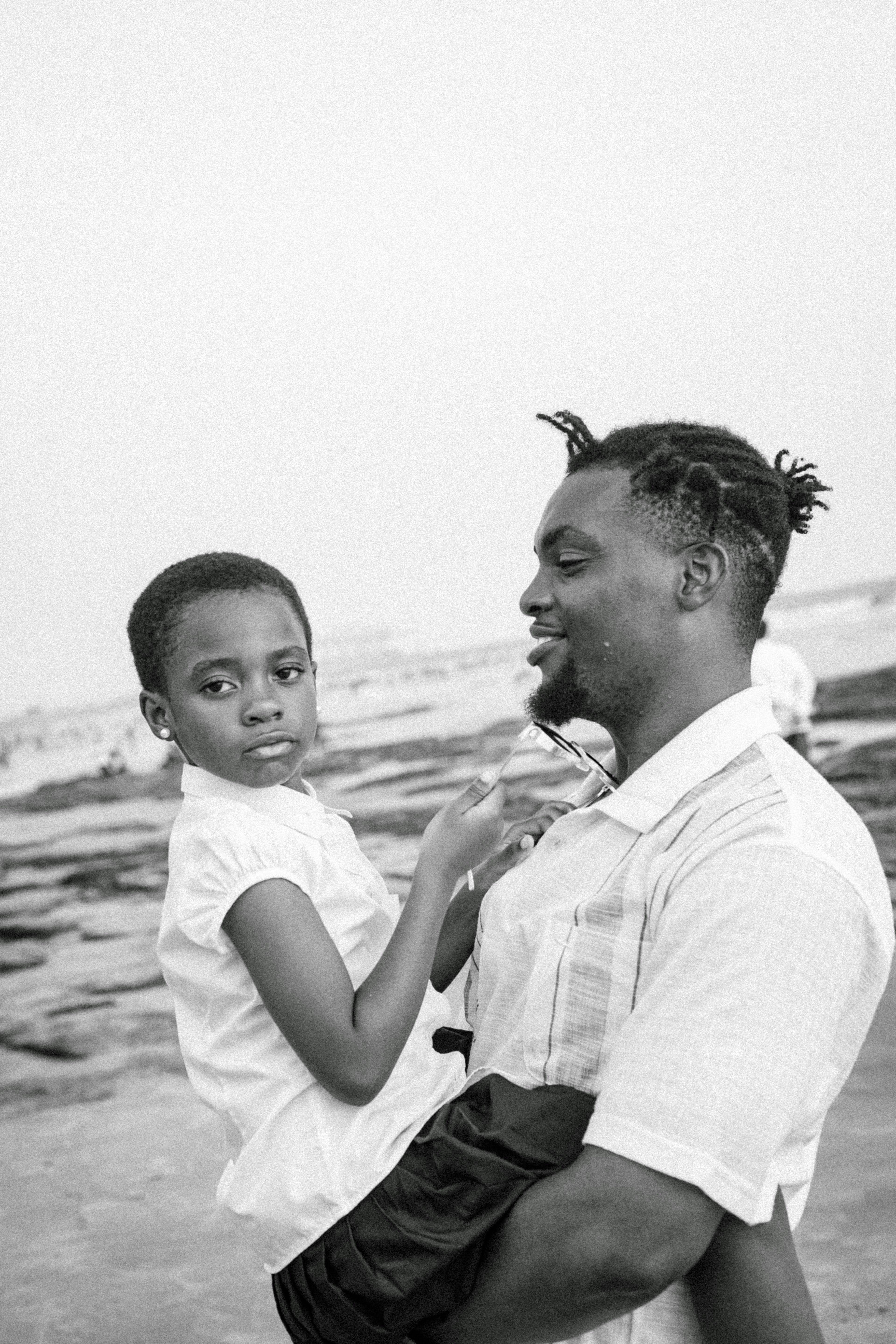 Father and daughter on the shore: a quiet bond in monochrome