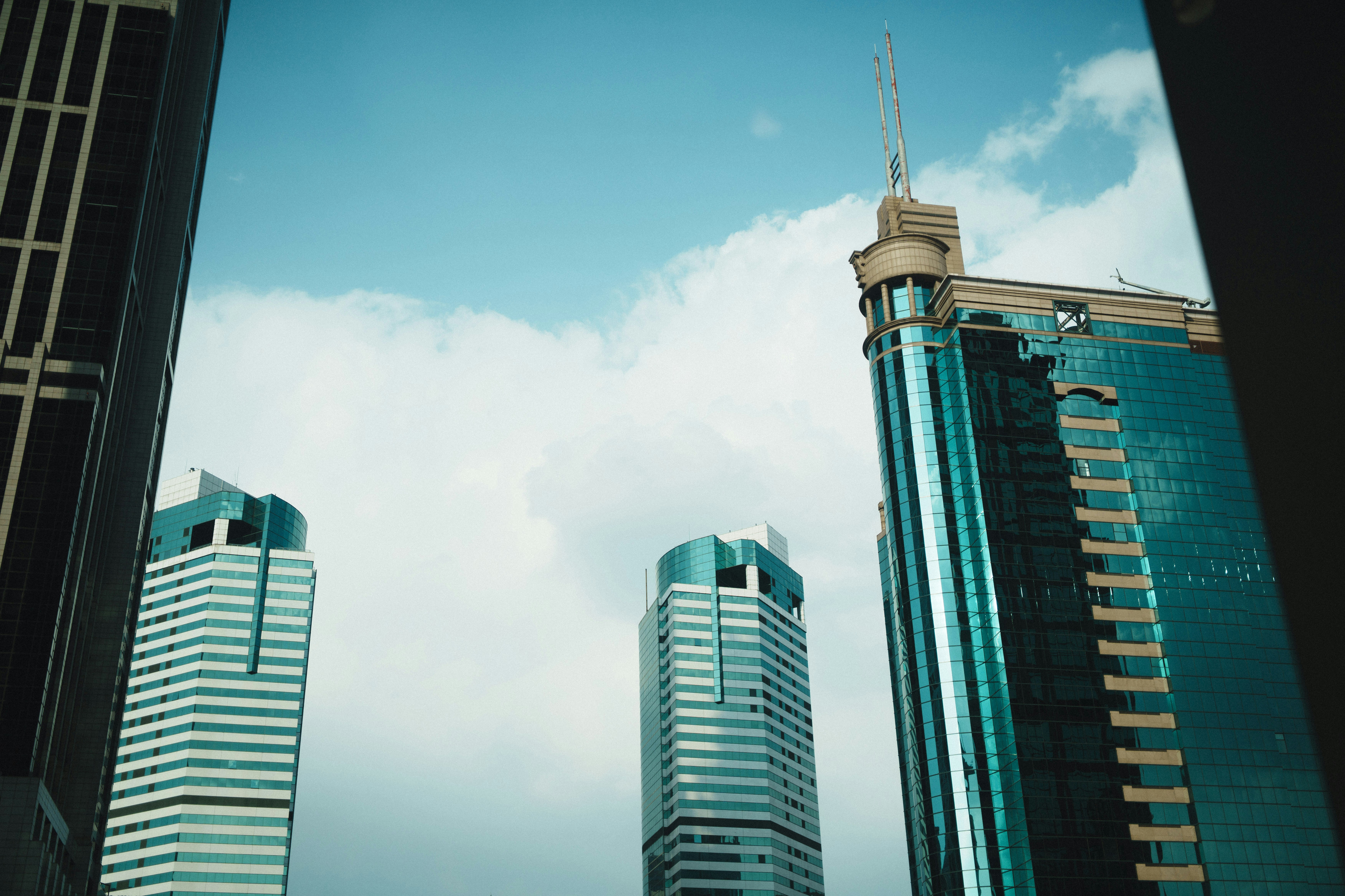 Skyward Verge: Glass Facades and Floating Clouds Behind a Framed Skyline