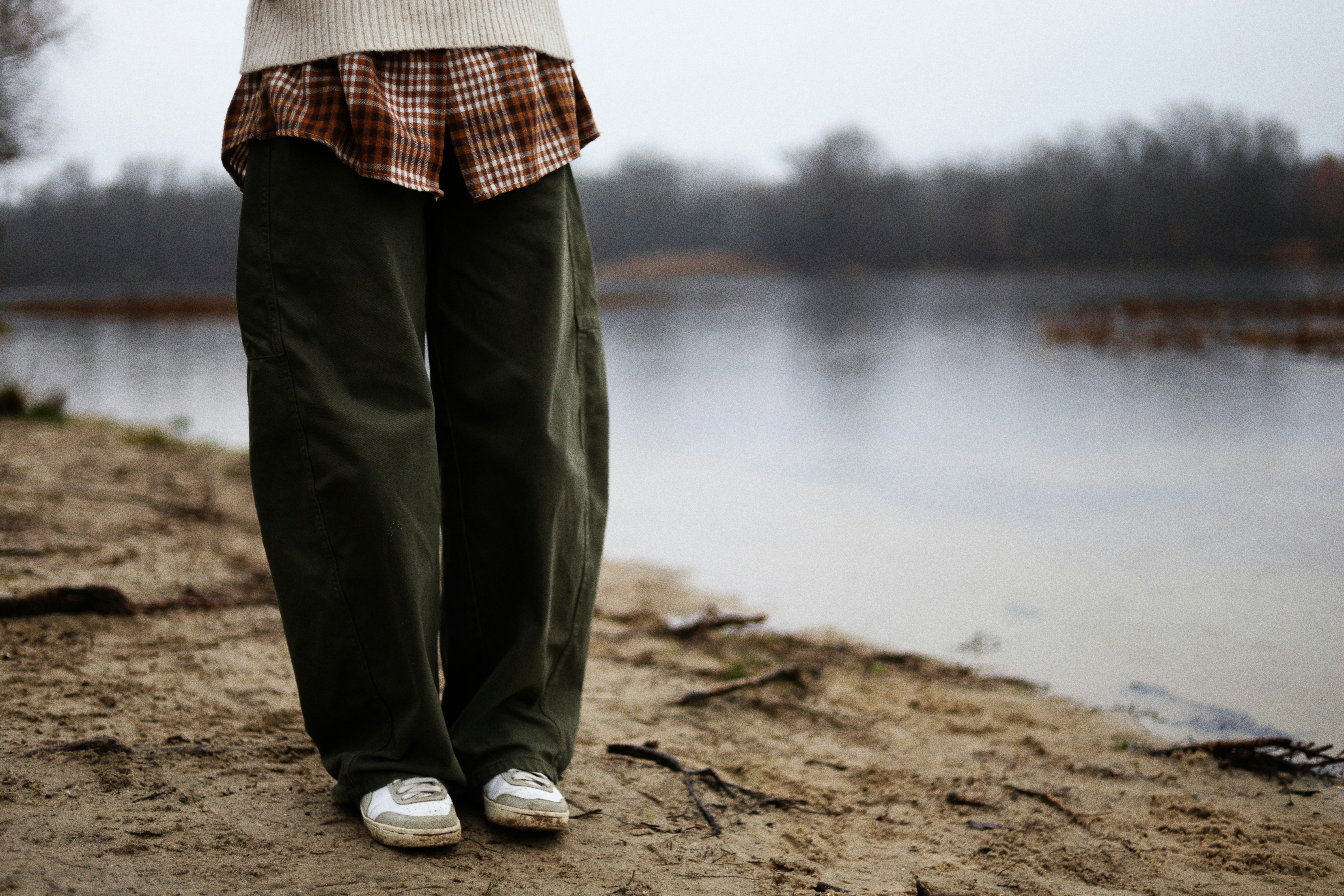Low-slung shoreline: a pair of weathered sneakers at the edge of quiet water