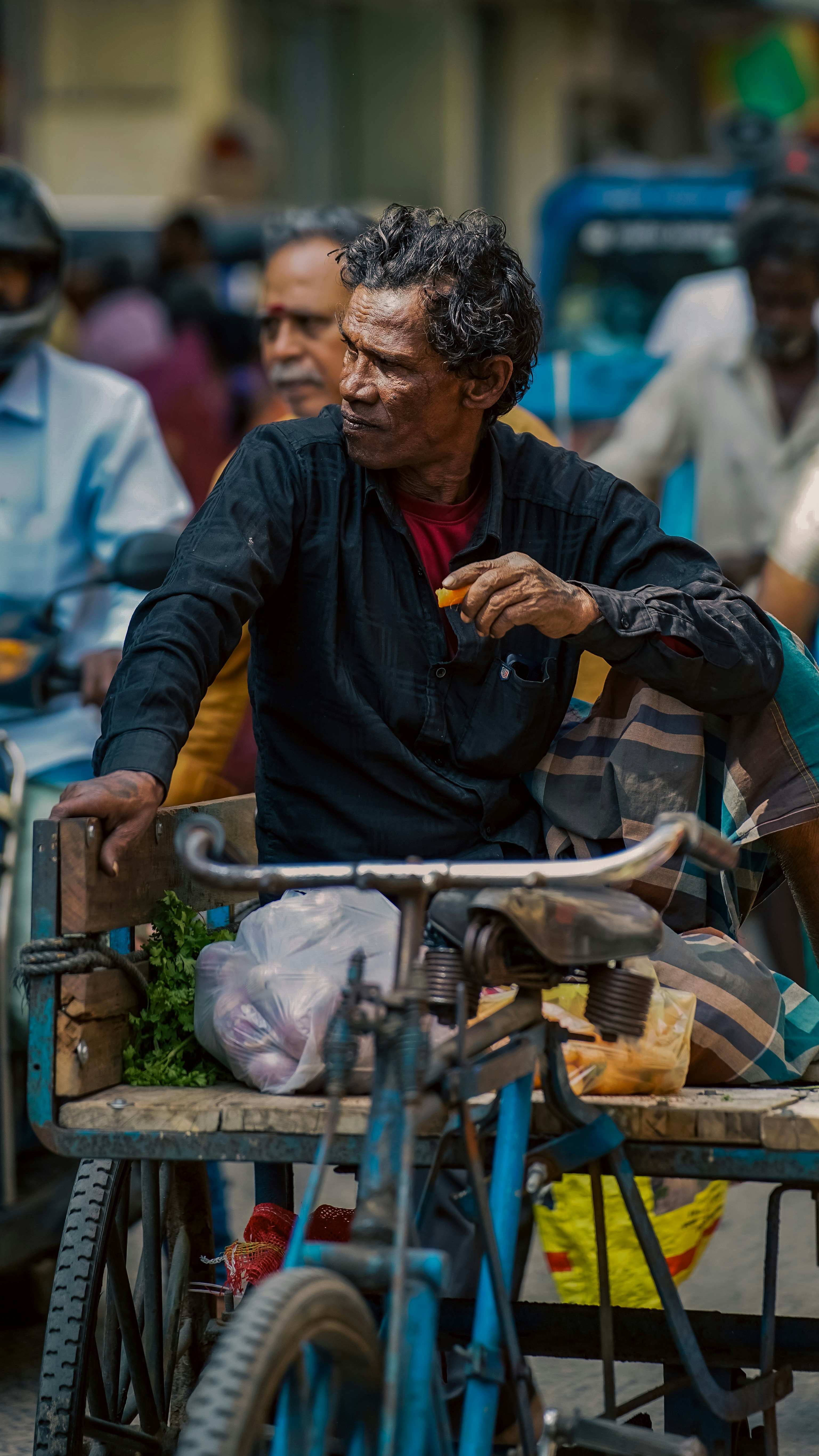 Portrait of a Street Vendor: Focused Gaze Amid Busy Street Life