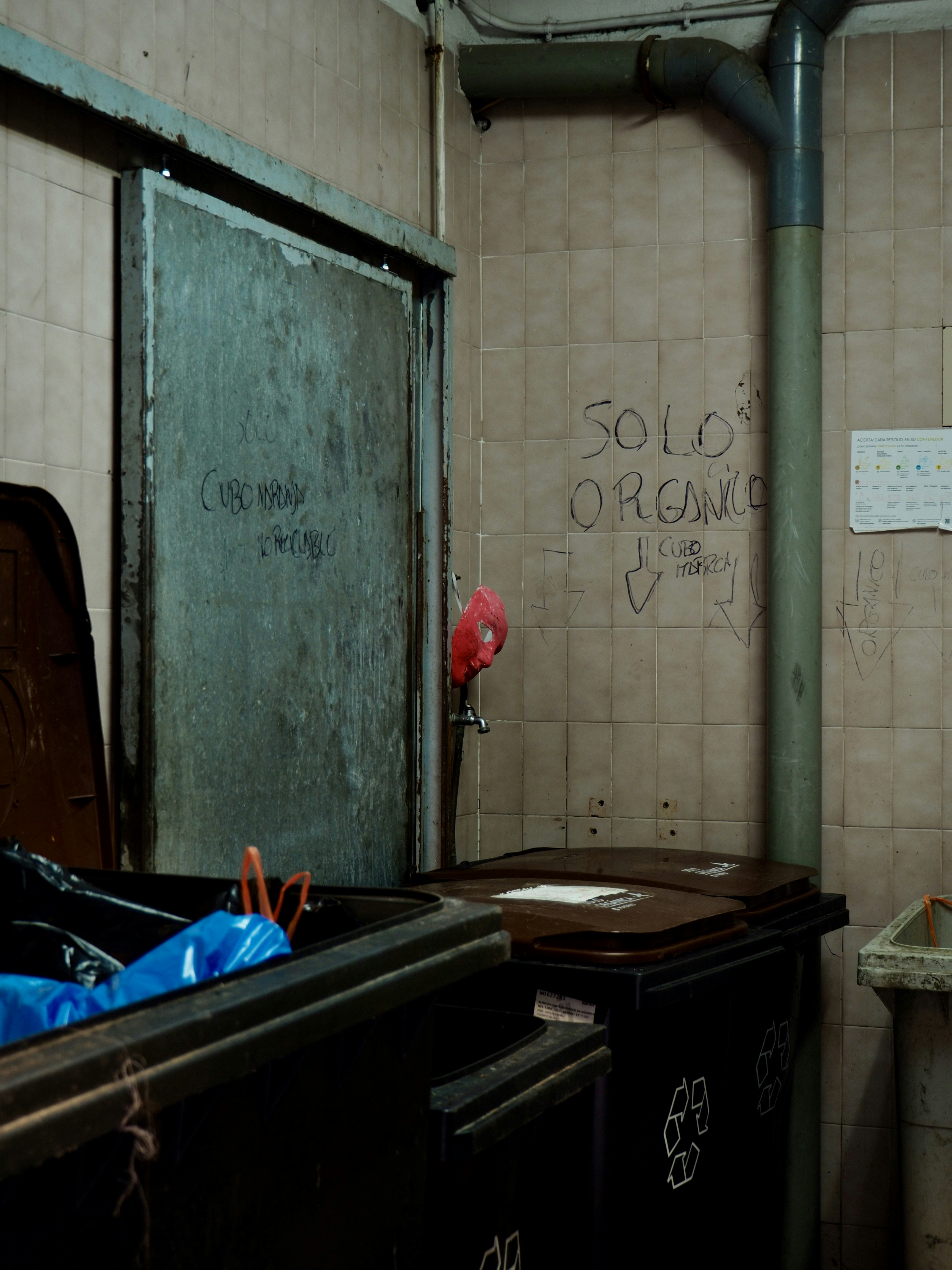 Red Valve, Grey Walls: An Urban Trash Scene