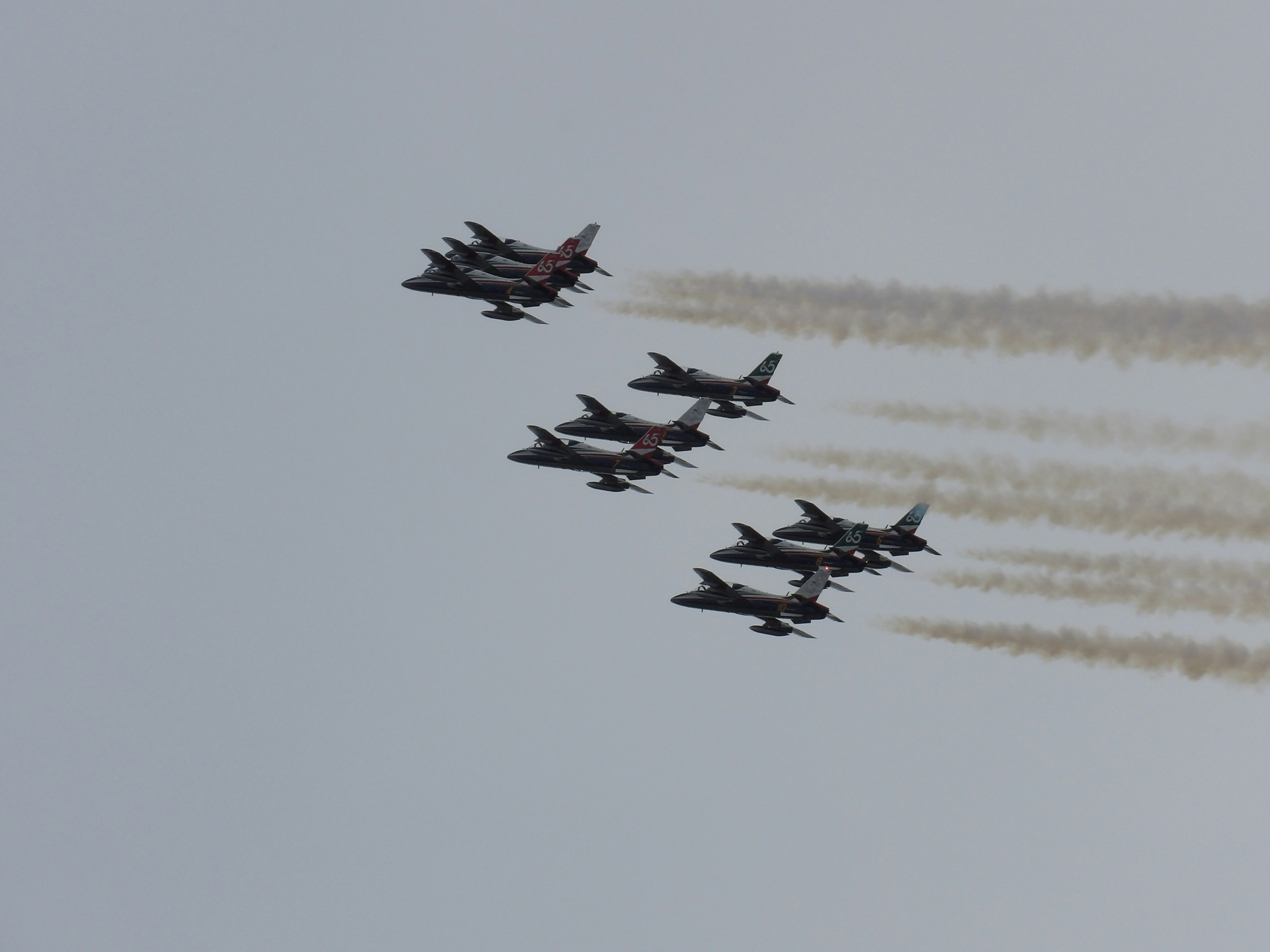 Six fighter jets fly in formation leaving smoke trails