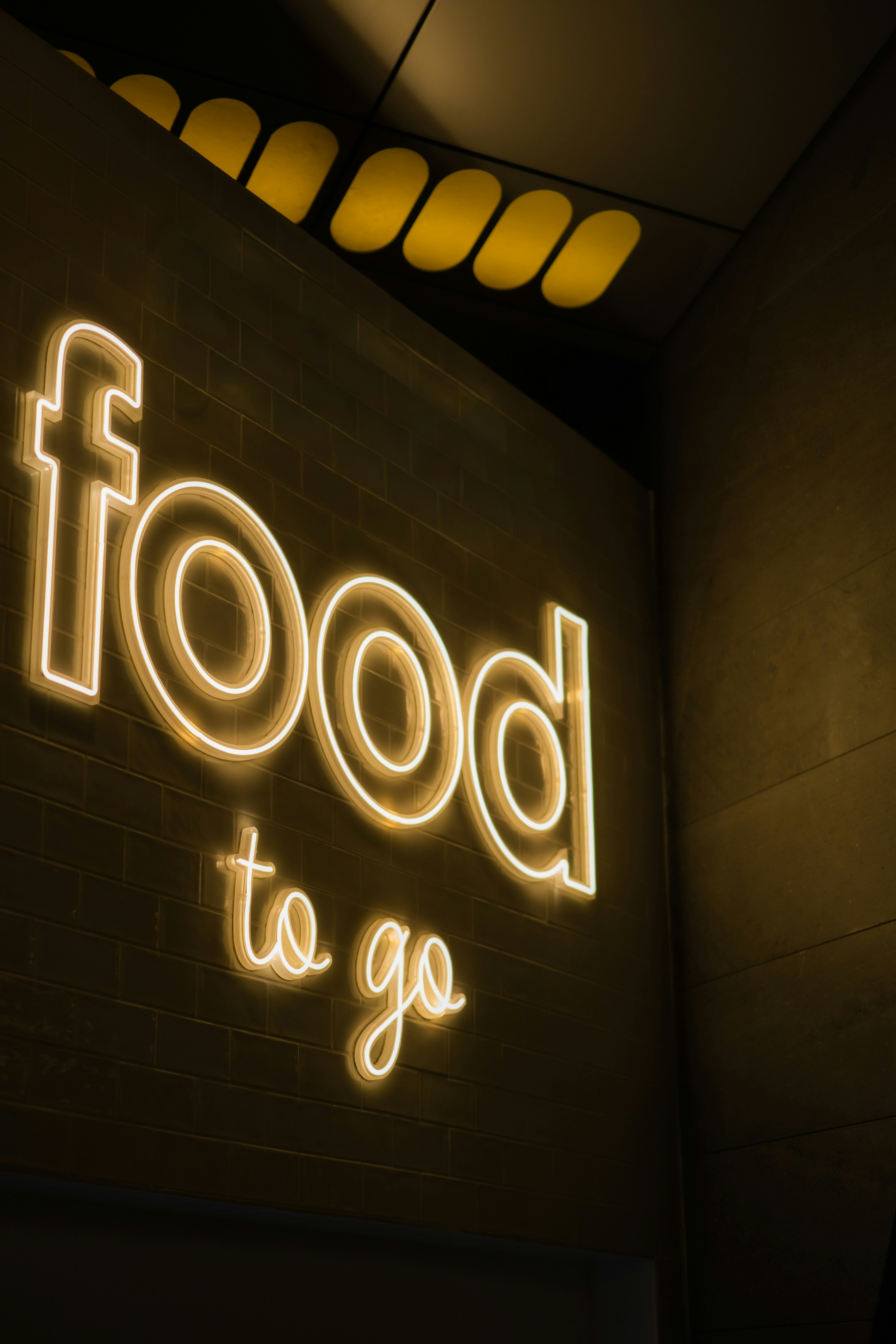 Glow Behind the Neon: Food Sign in Dim Urban Light