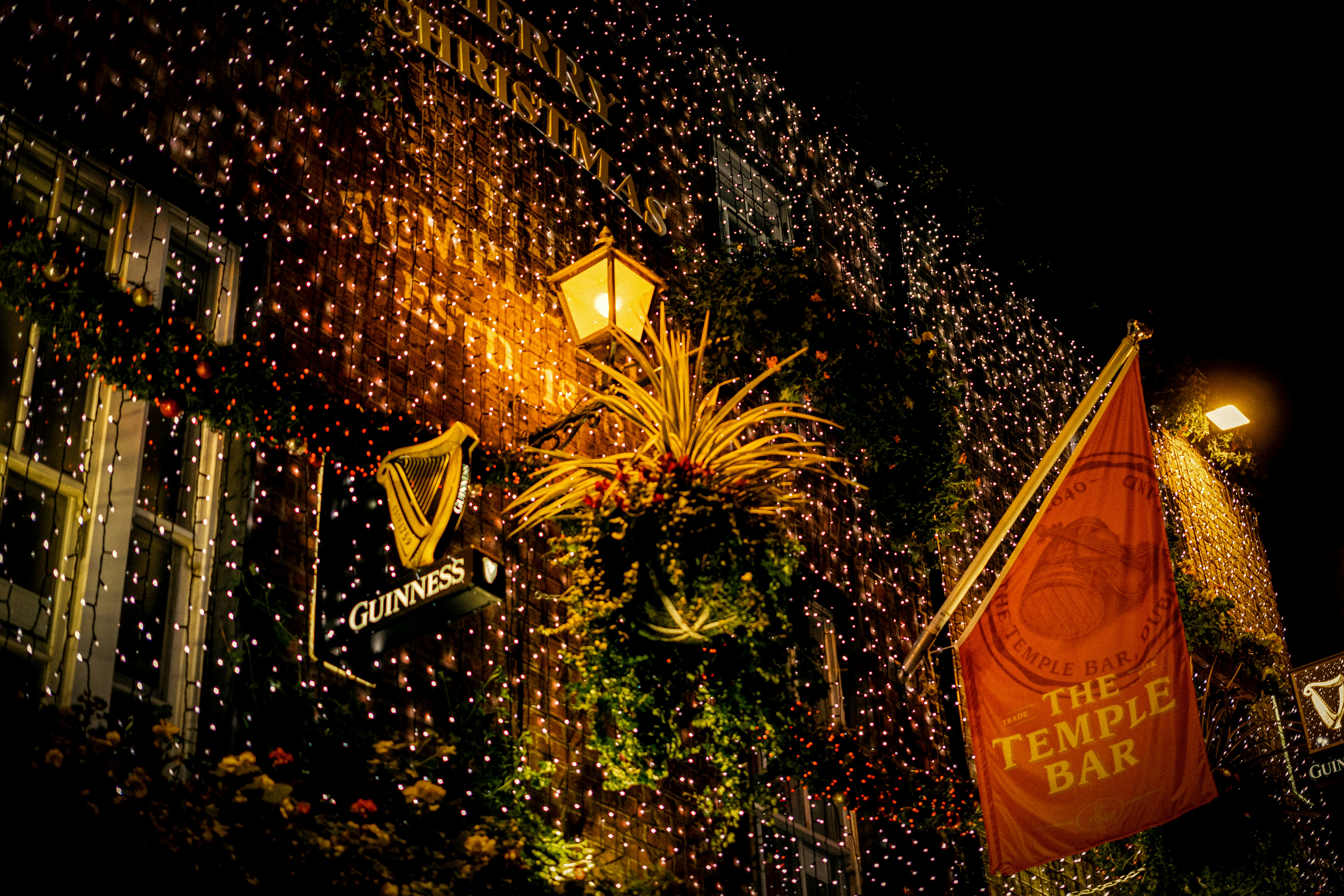 Night luminance over Temple Bar: festive orbs weaving through a city storefront