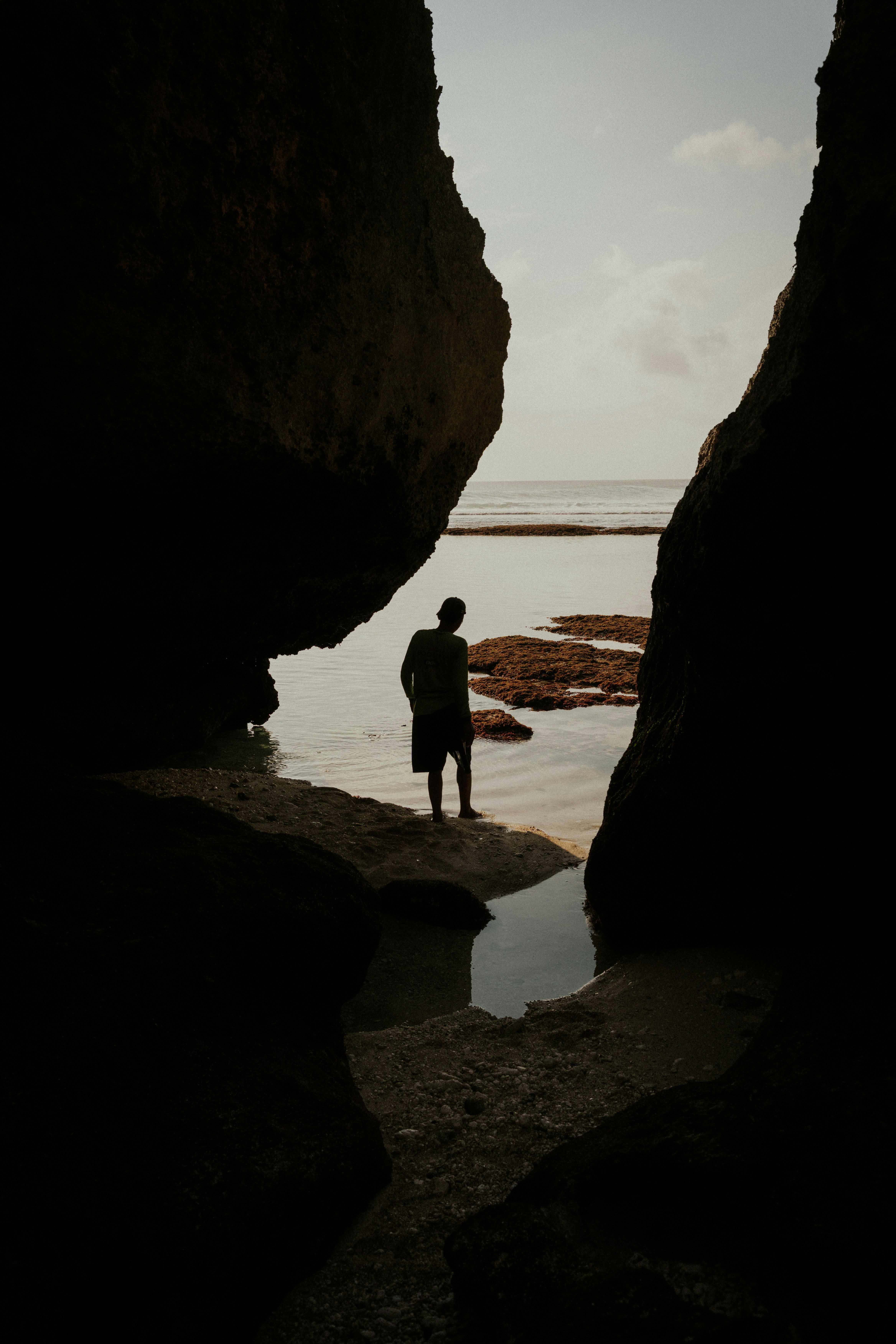Silent Gull Against the Opening: A Lone Figure at the Mouth of a Sea-Wlooded V Between Cliffs