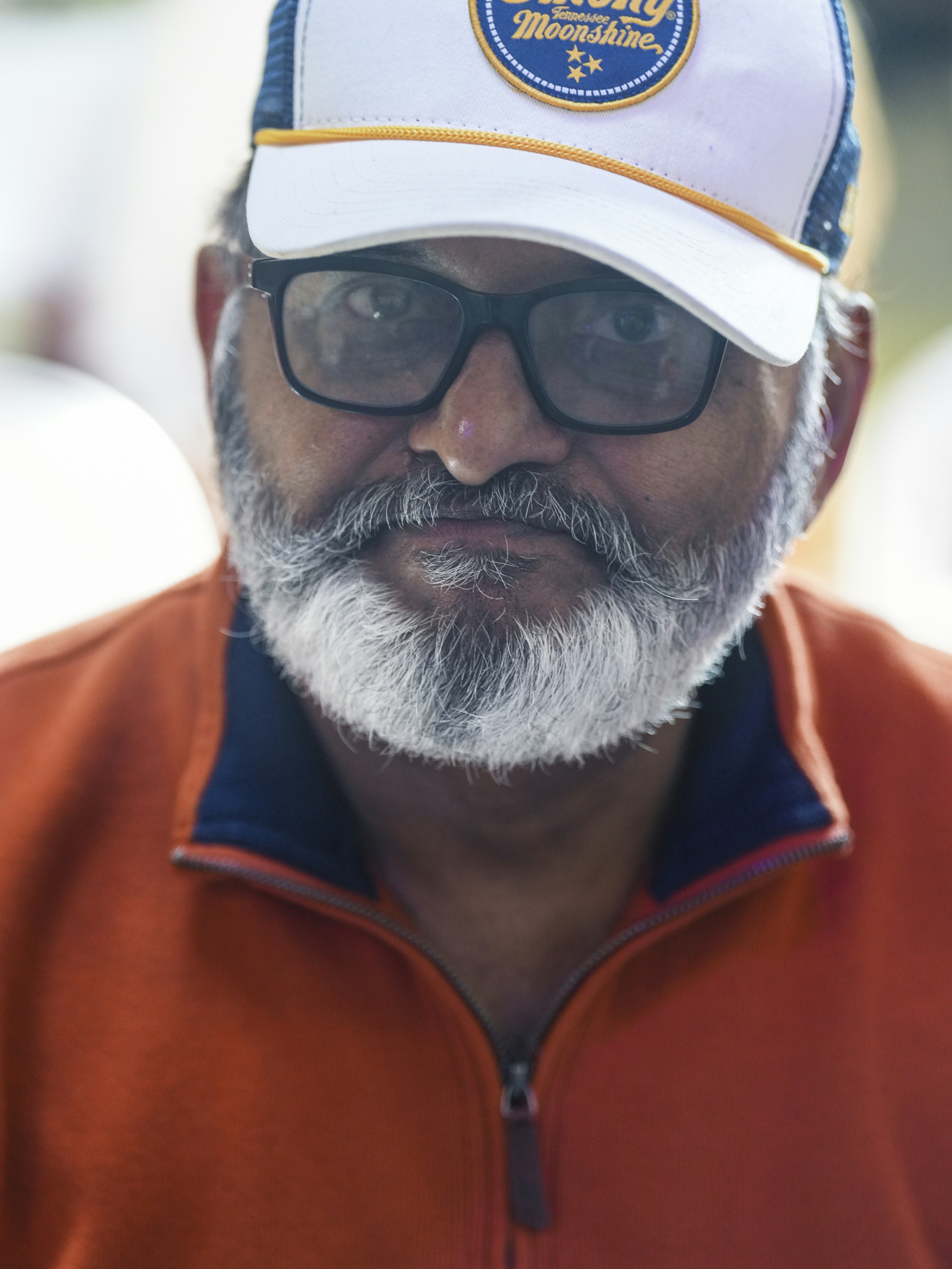 Eyes Behind the Glass: A Close Portrait of a Bearded Man in a Cap