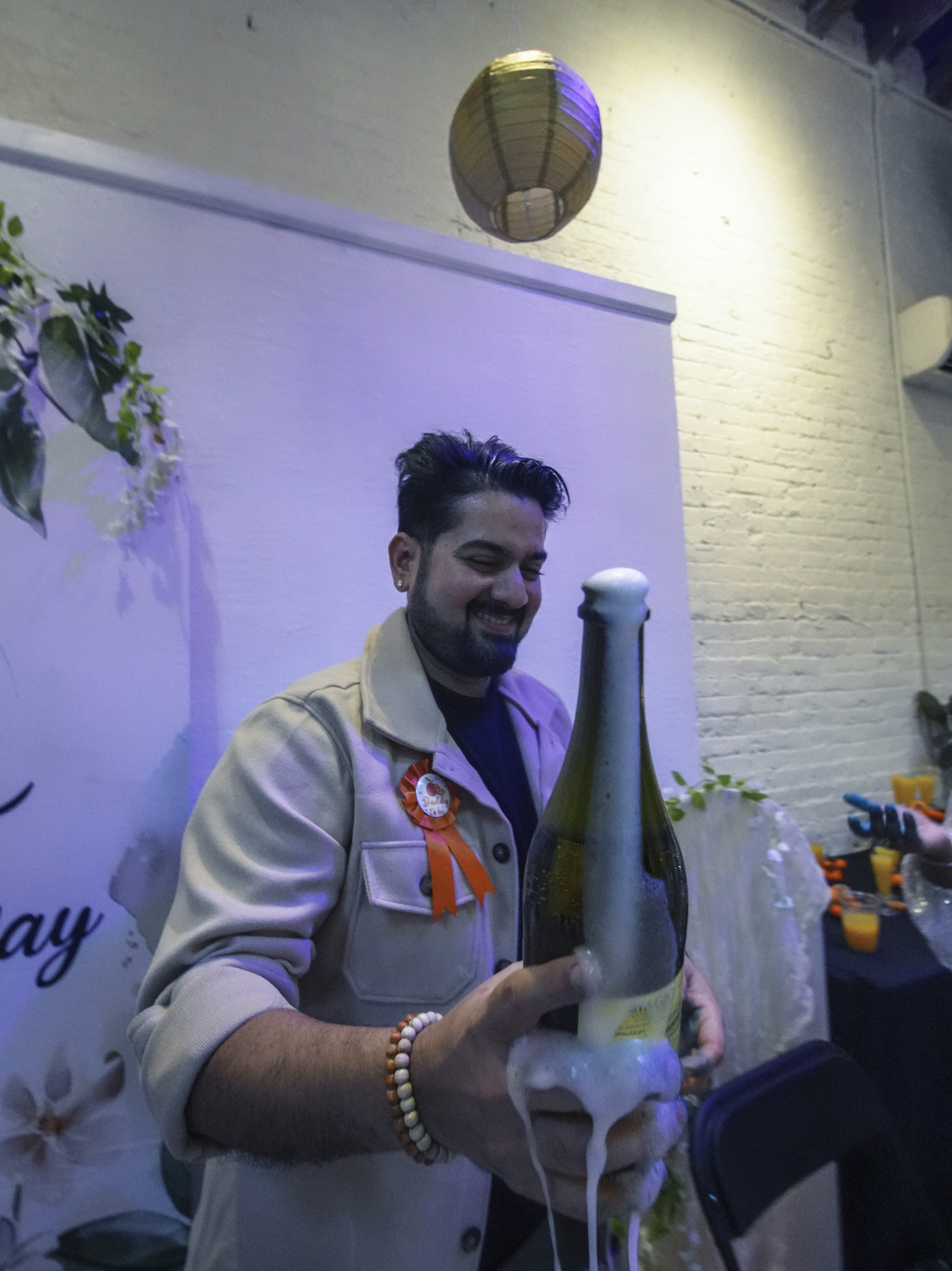 Champagne Moment: A celebrant Grins as Foam Foams Over a Bottle