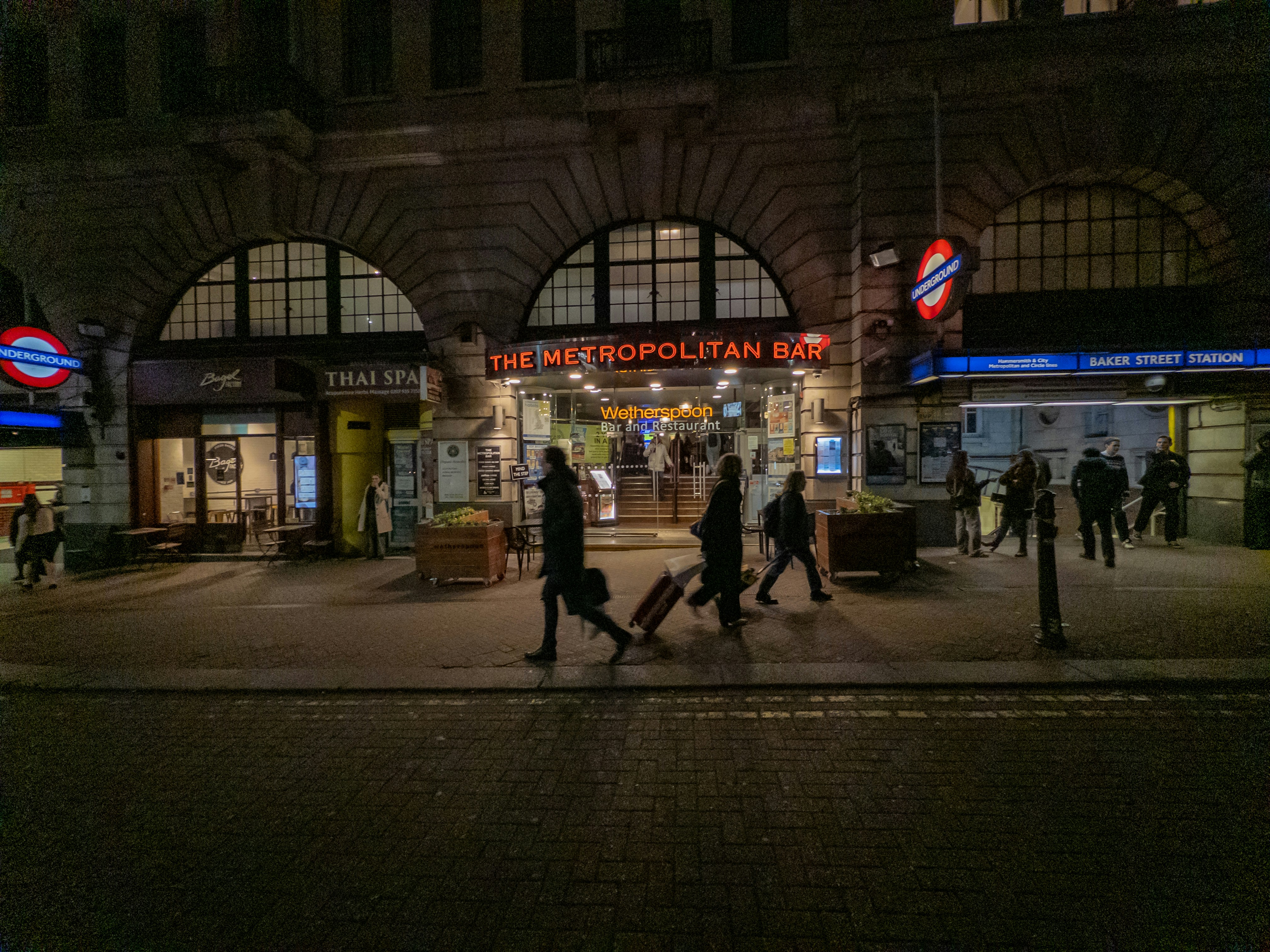 Nightlife on the Strand: Pedestrians Cross in Front of The Metropolitan Bar