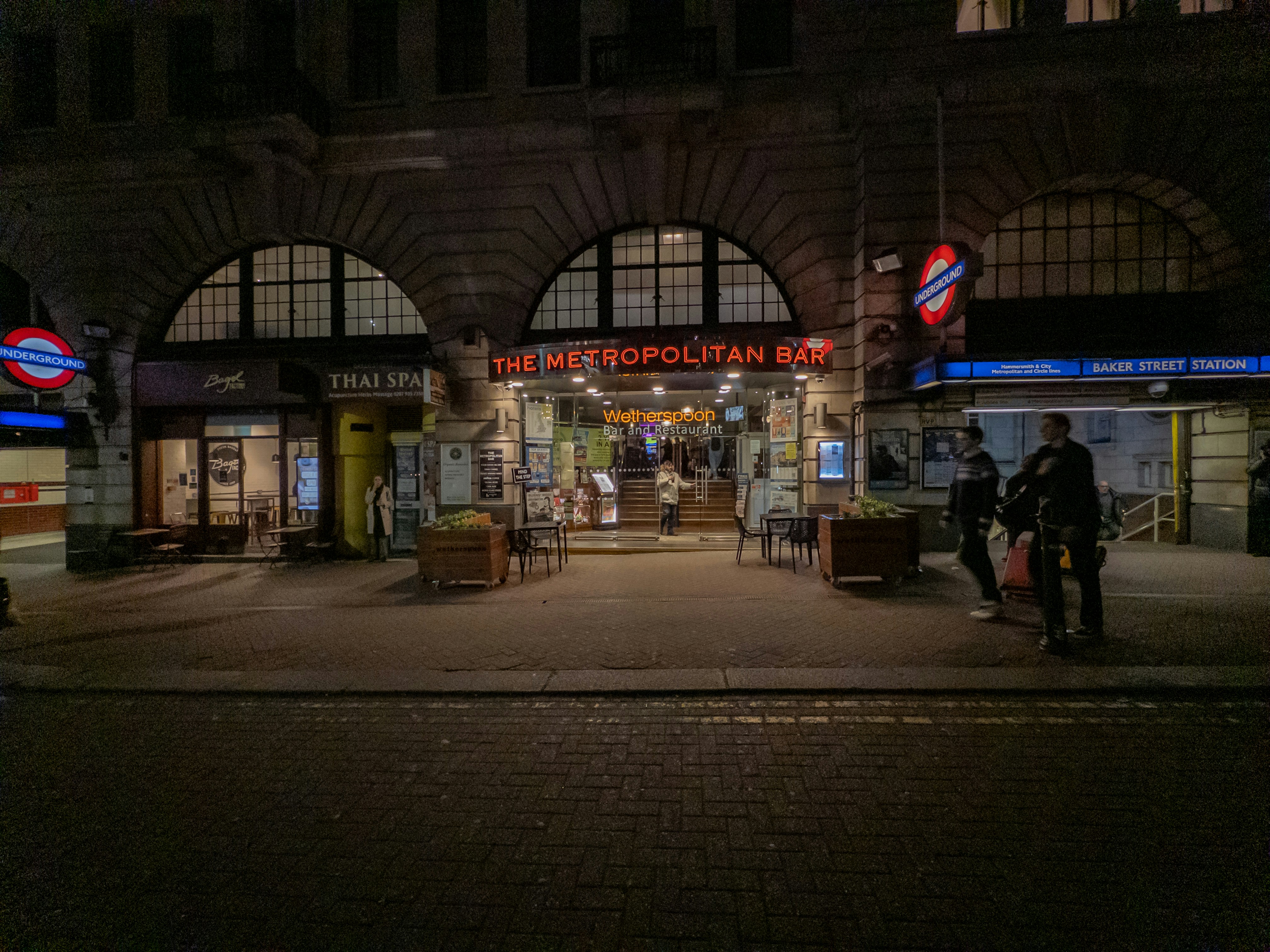Nightlife at the Metropolitan Bar: Neon Welcome Under Arched Windows