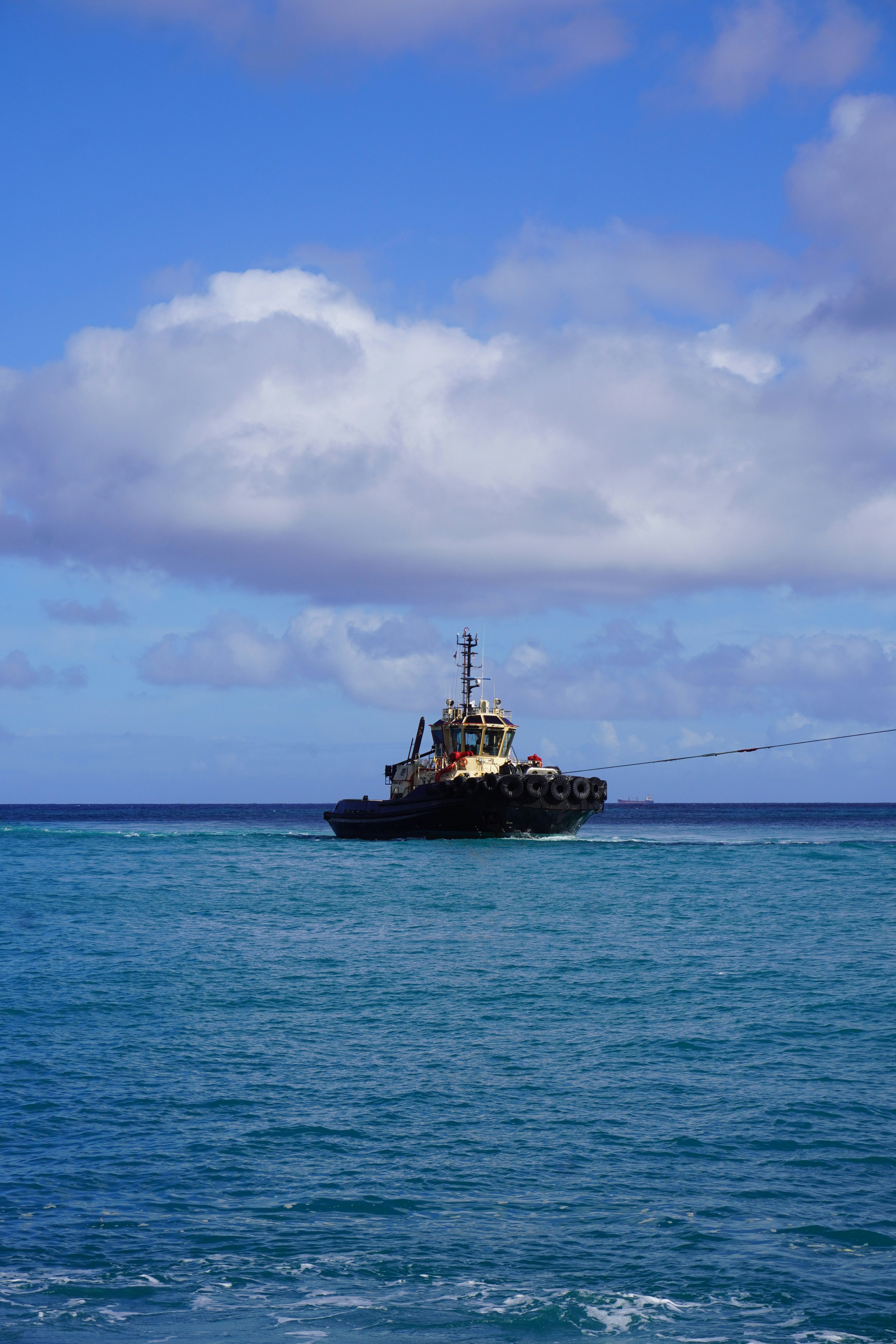 Towline at Dusk: Tug Drifts toward the Horizon