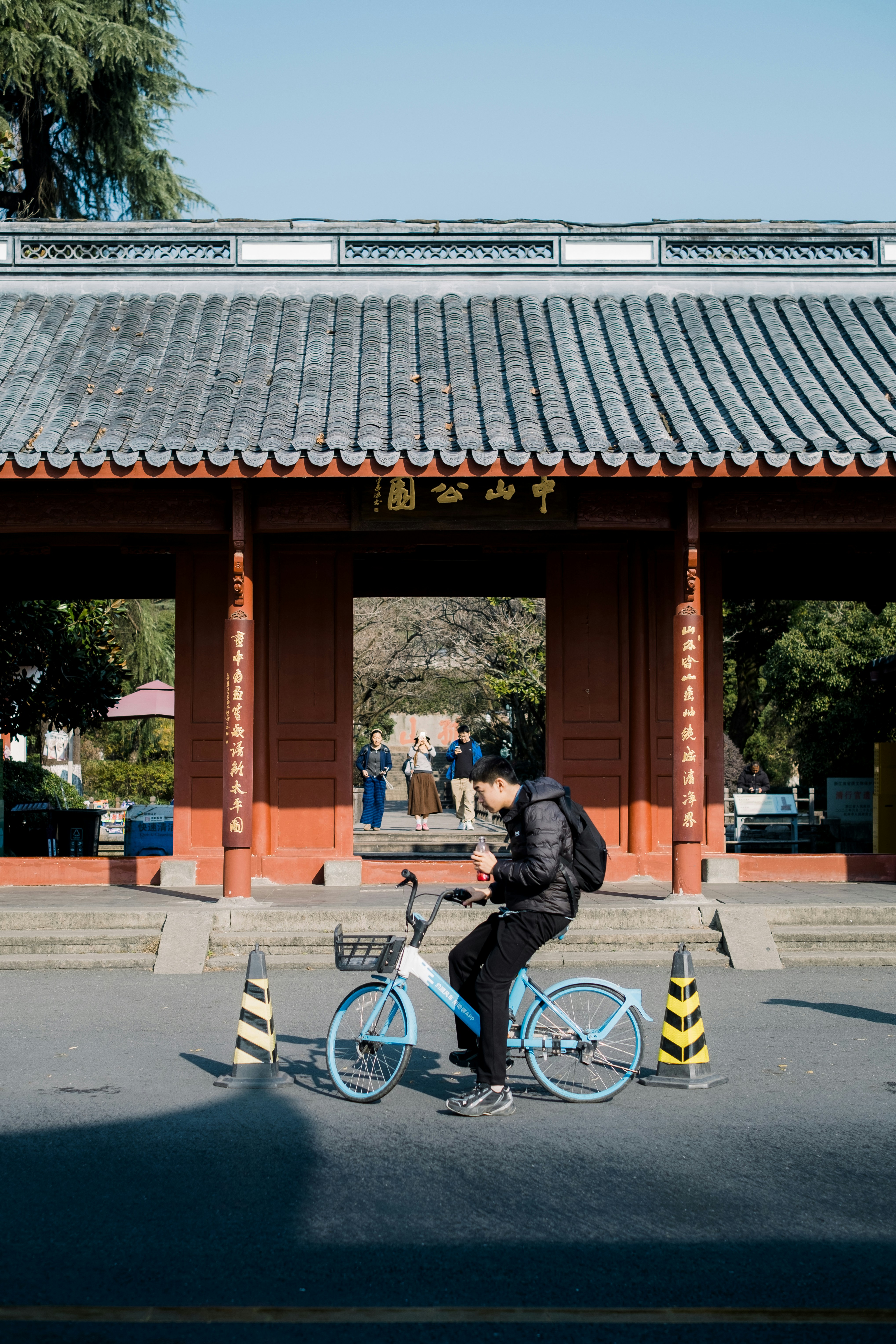 Rider in Front of a Traditional Gate: urban calm under tiled roof